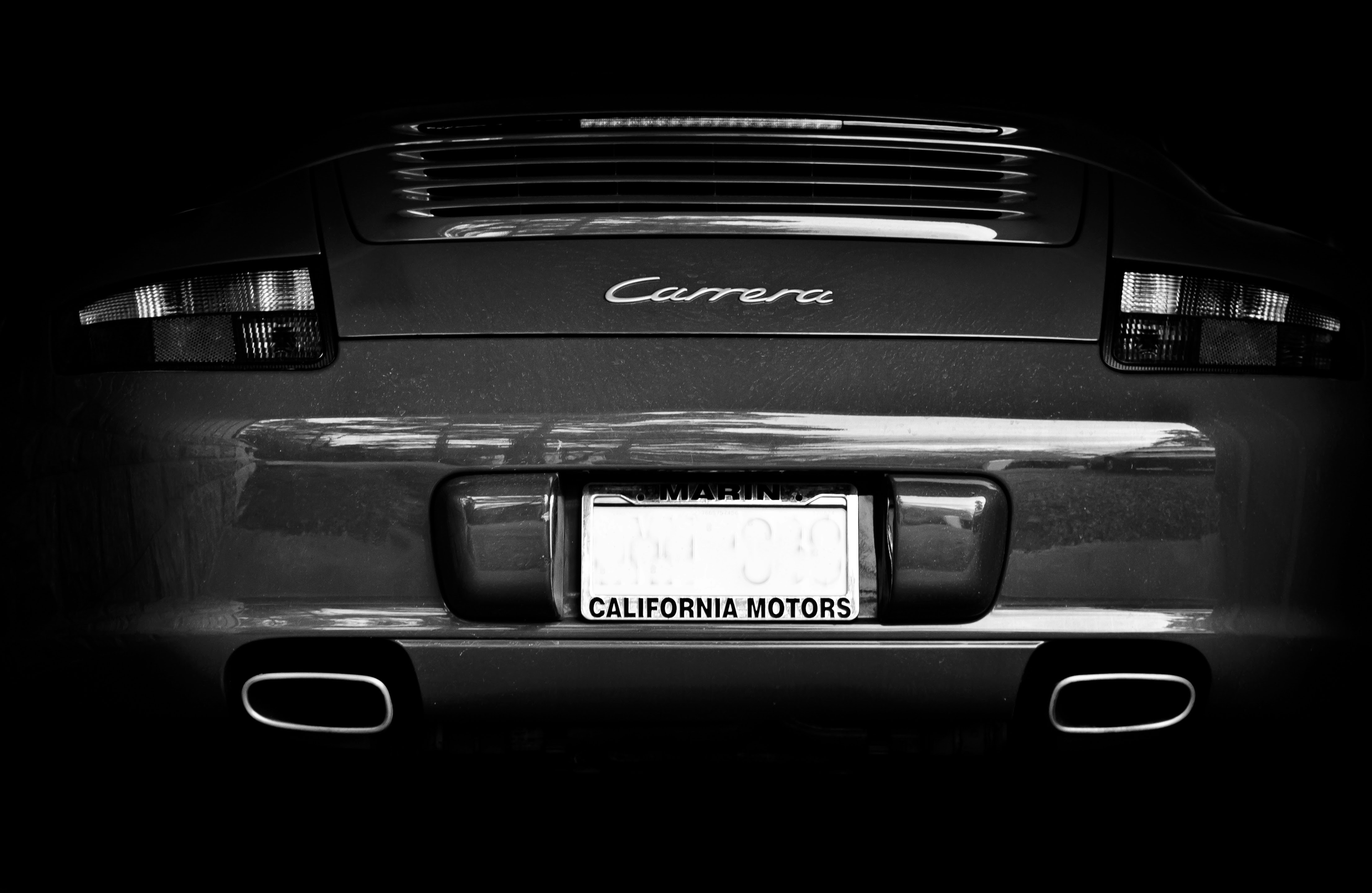 Midnight Carrera: monochrome rear silhouette with chrome exhausts