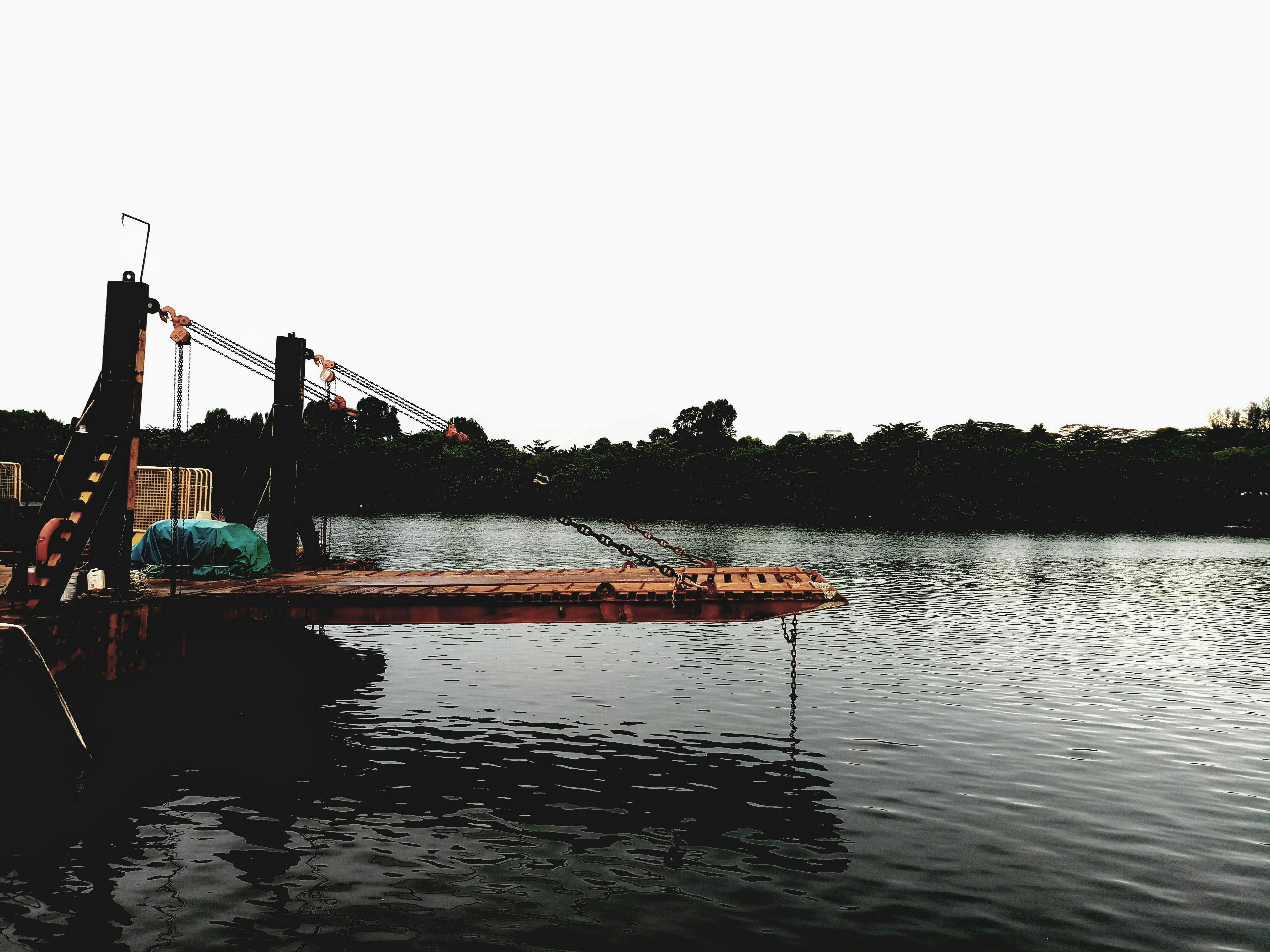 Dusk at the Quiet Jetty: A Weathered Dock Reaches Into a Calm River