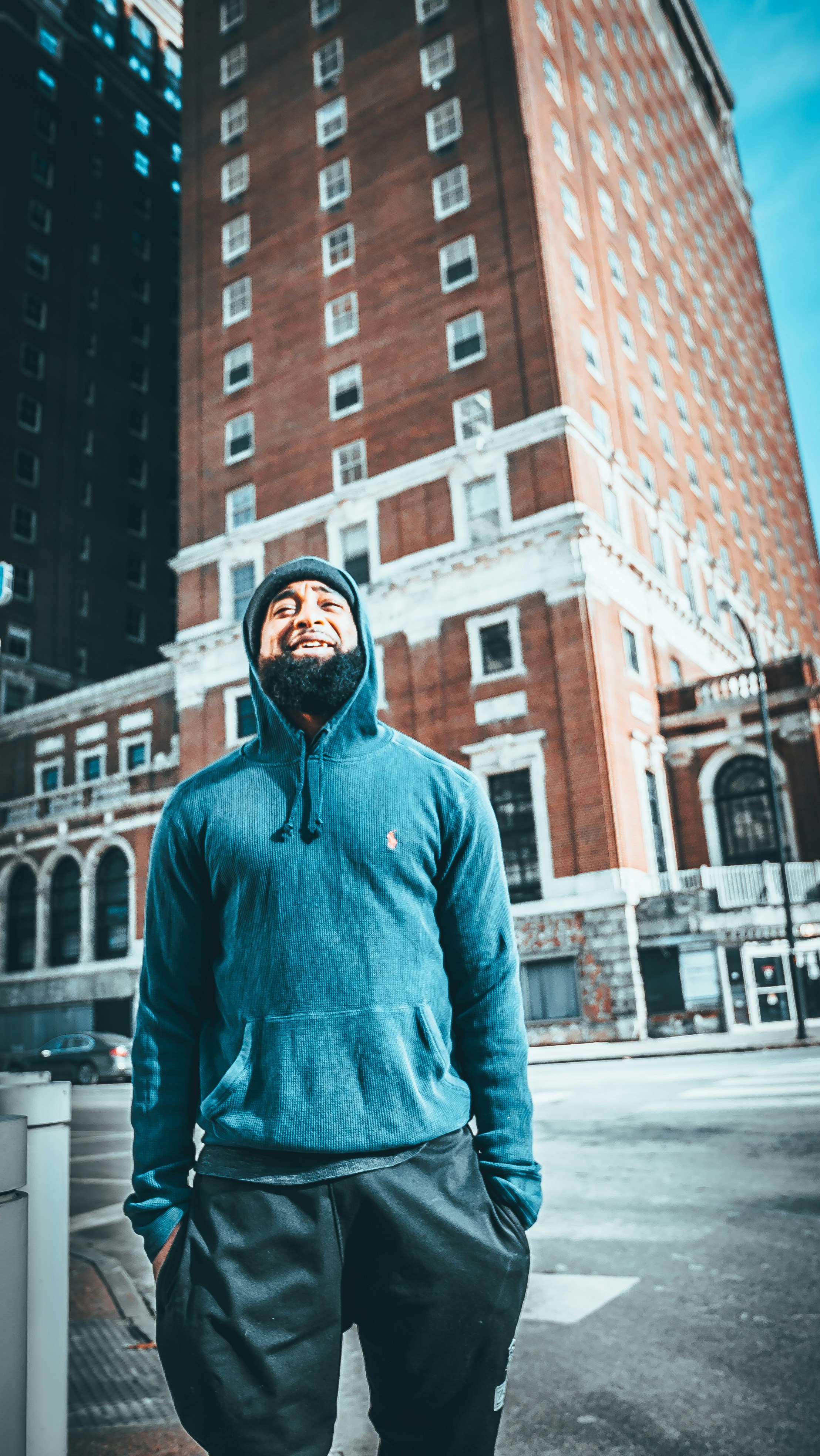 Urban Resolve: A Hoodie-Clad Moment Beneath Brick Giants