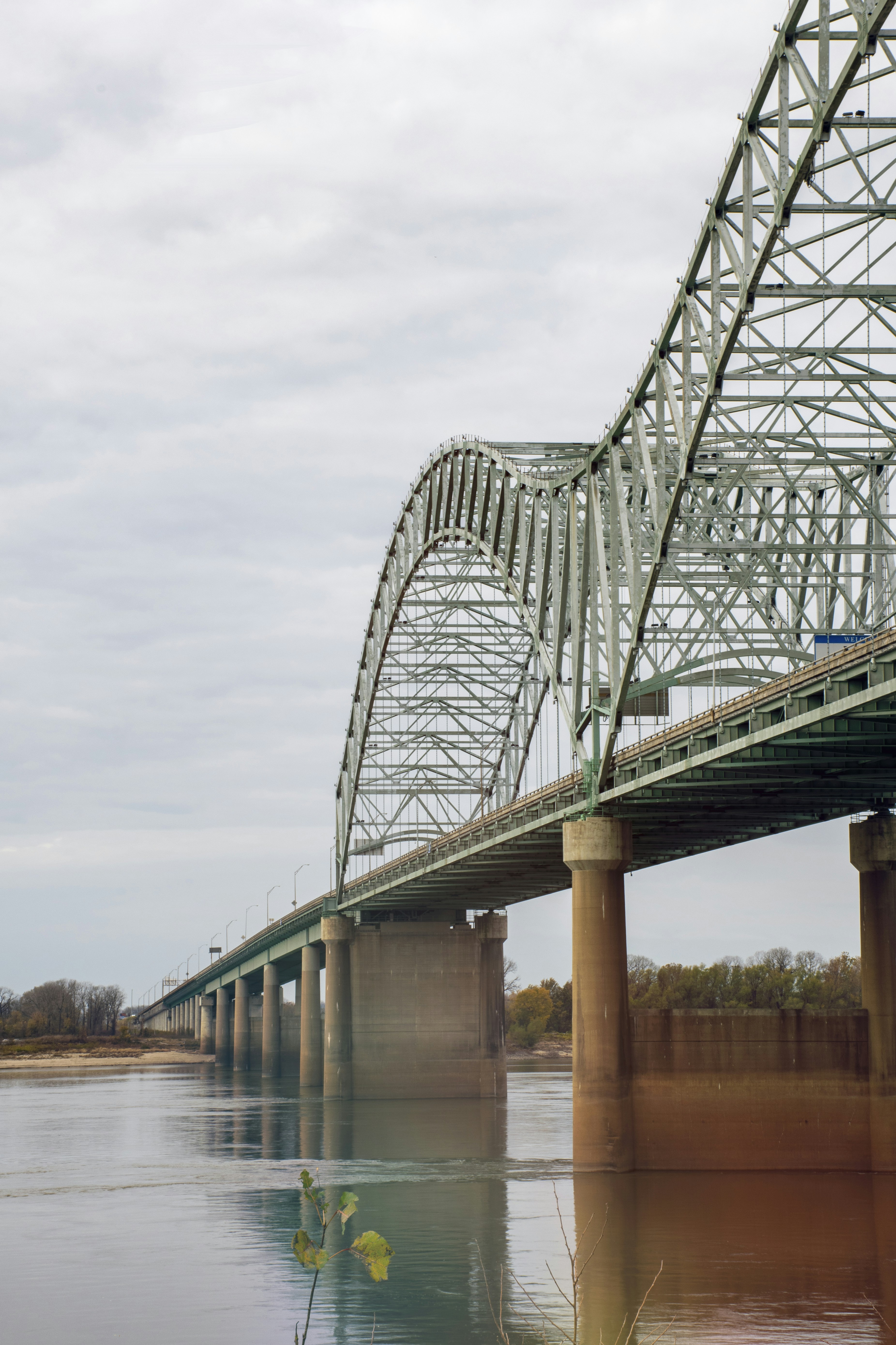 Gray metal bridge over river under white clouds during daytime photo ...