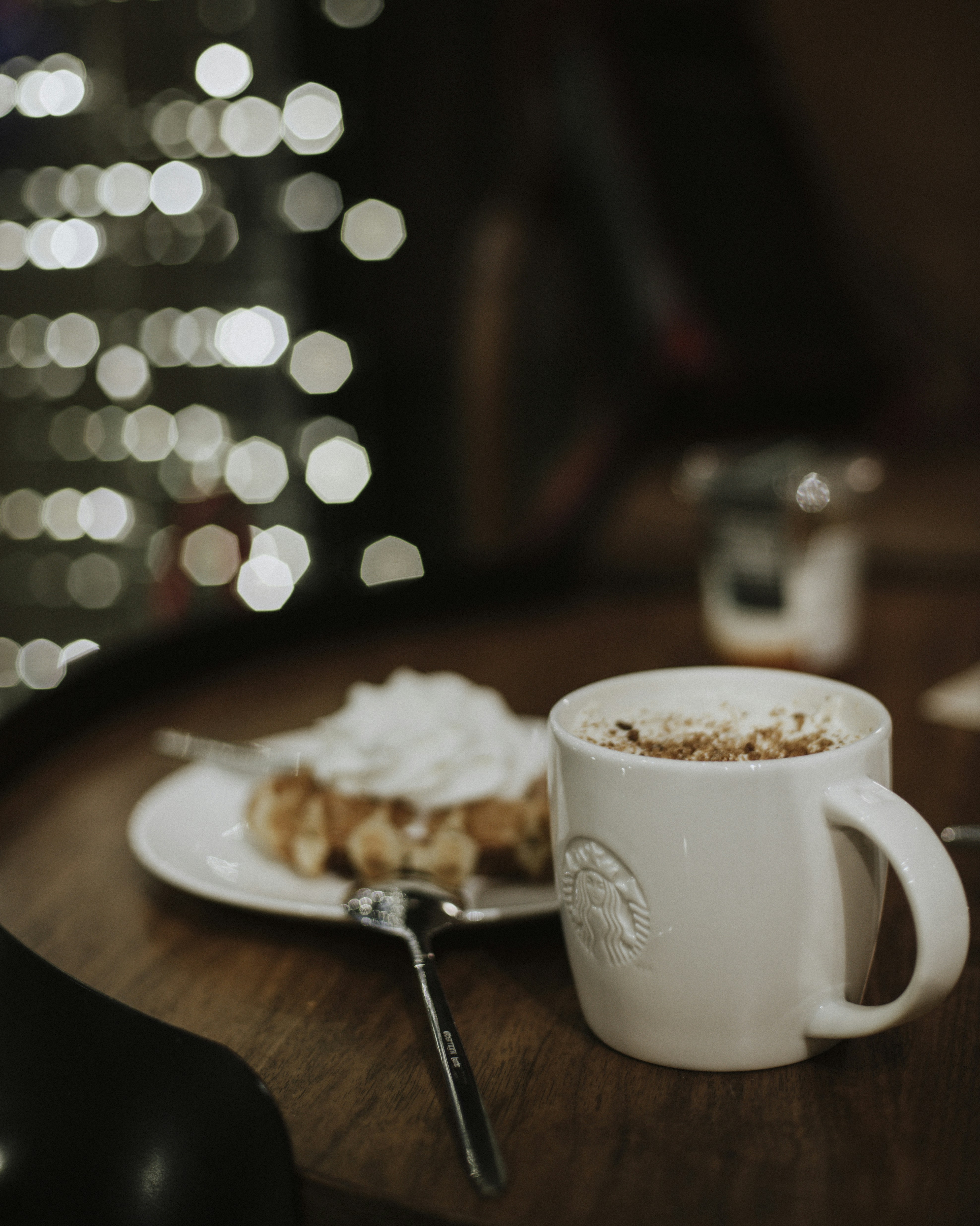 white ceramic mug on white ceramic plate beside stainless steel spoon