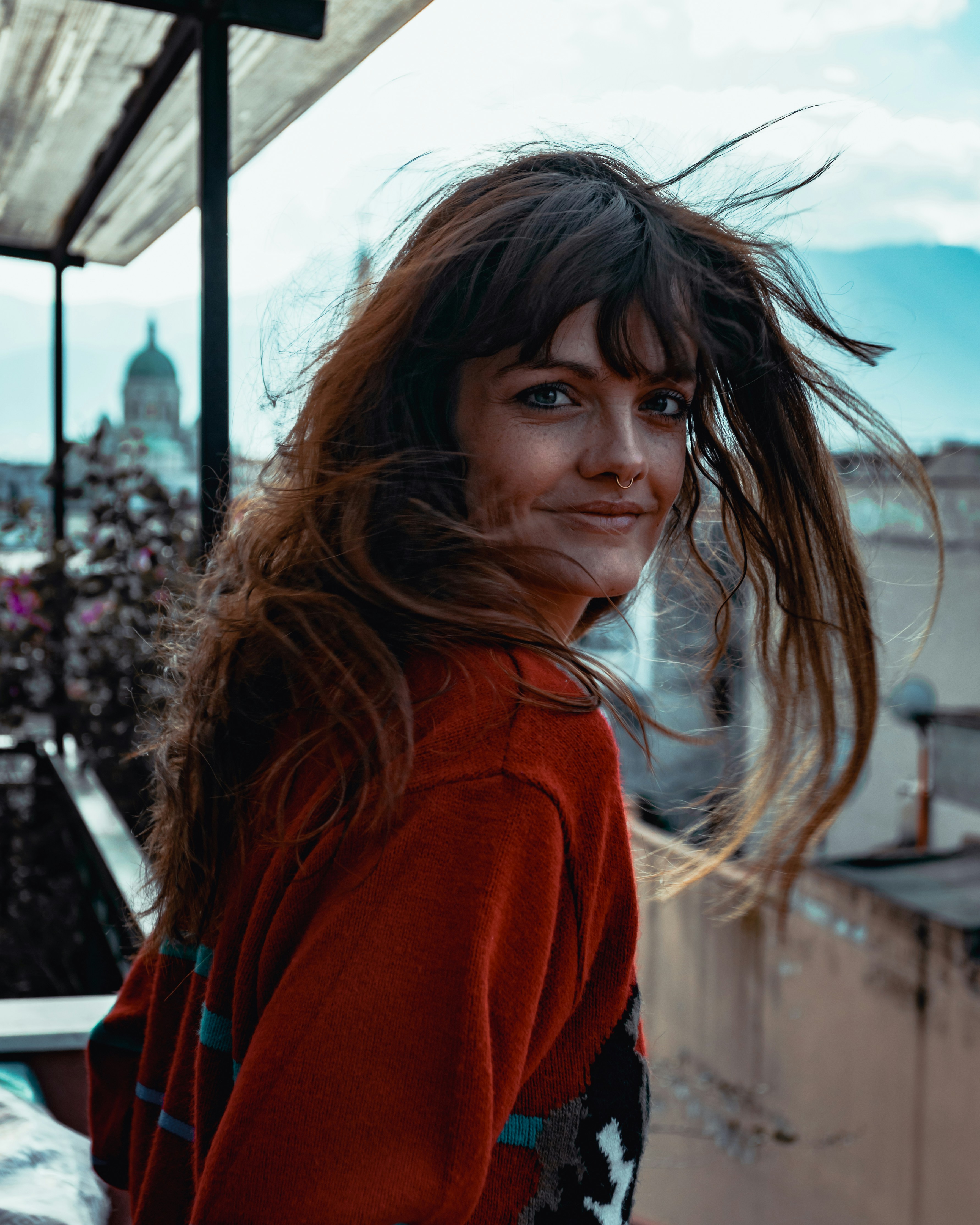 Wind-Woven Rooftop Portrait: Ember Hair Against the City
