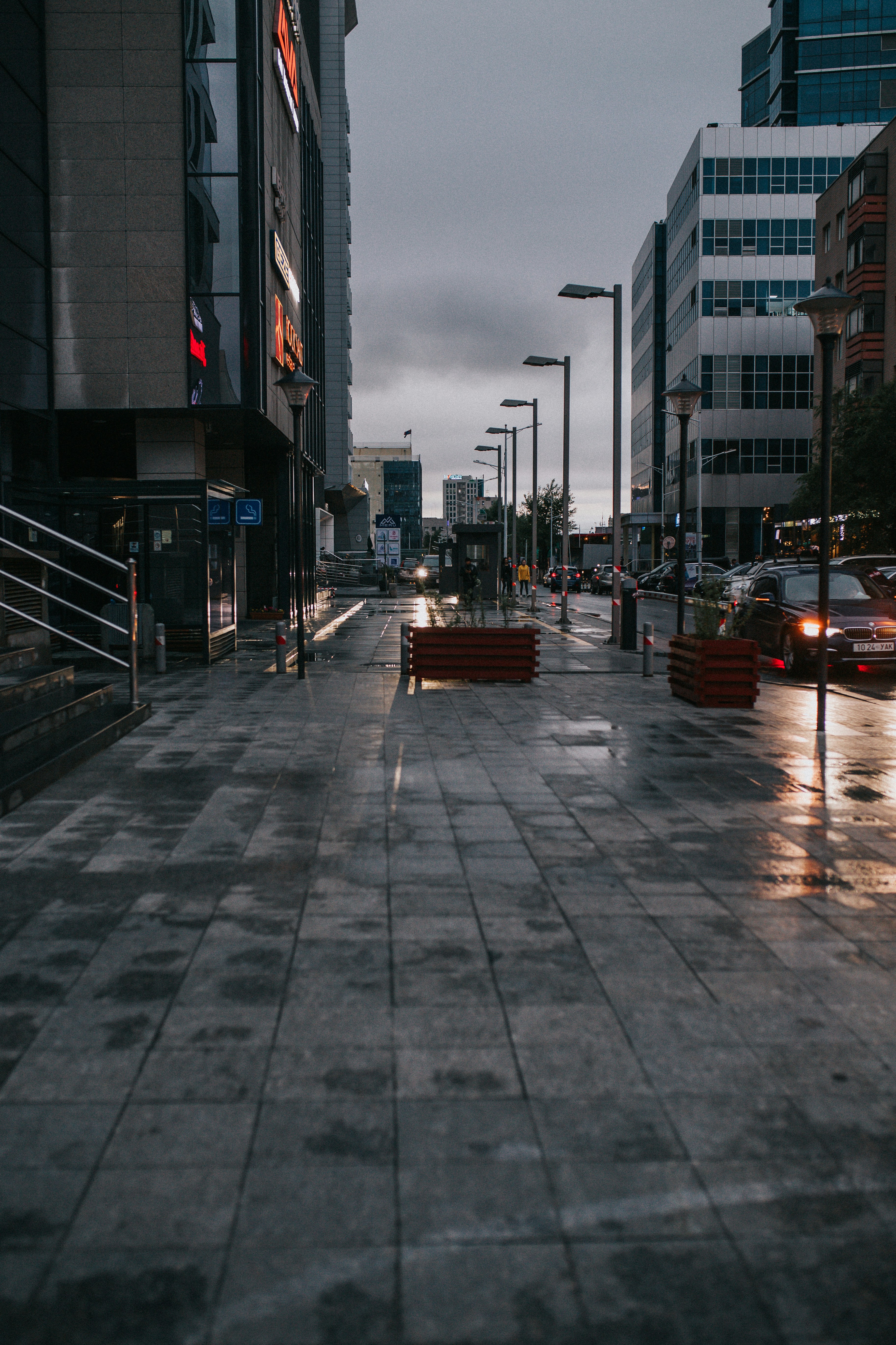 Downtown view after rain | black metal fence on sidewalk during daytime