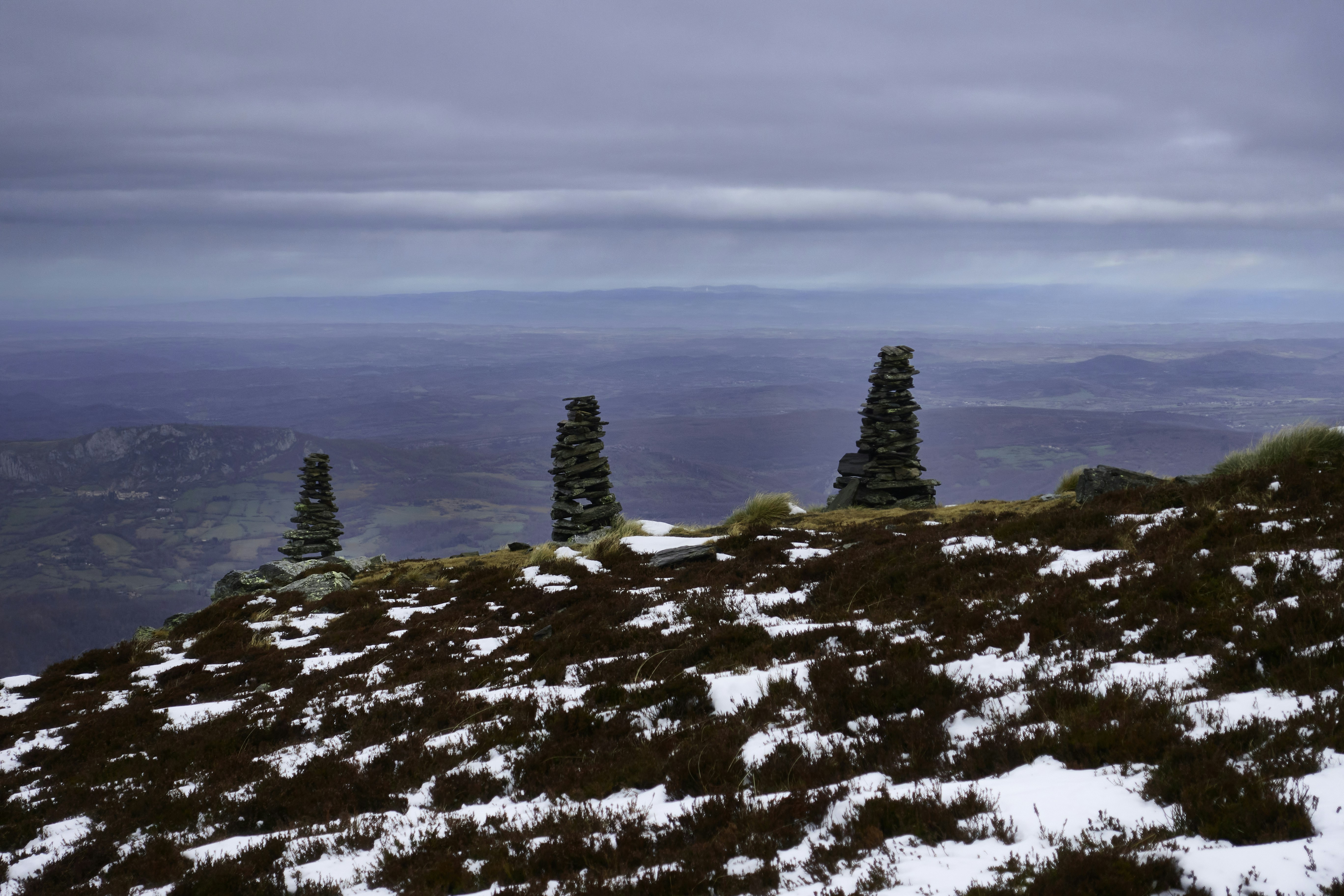 Three Stone Cairns Crown a Snow-Dusted Ridge