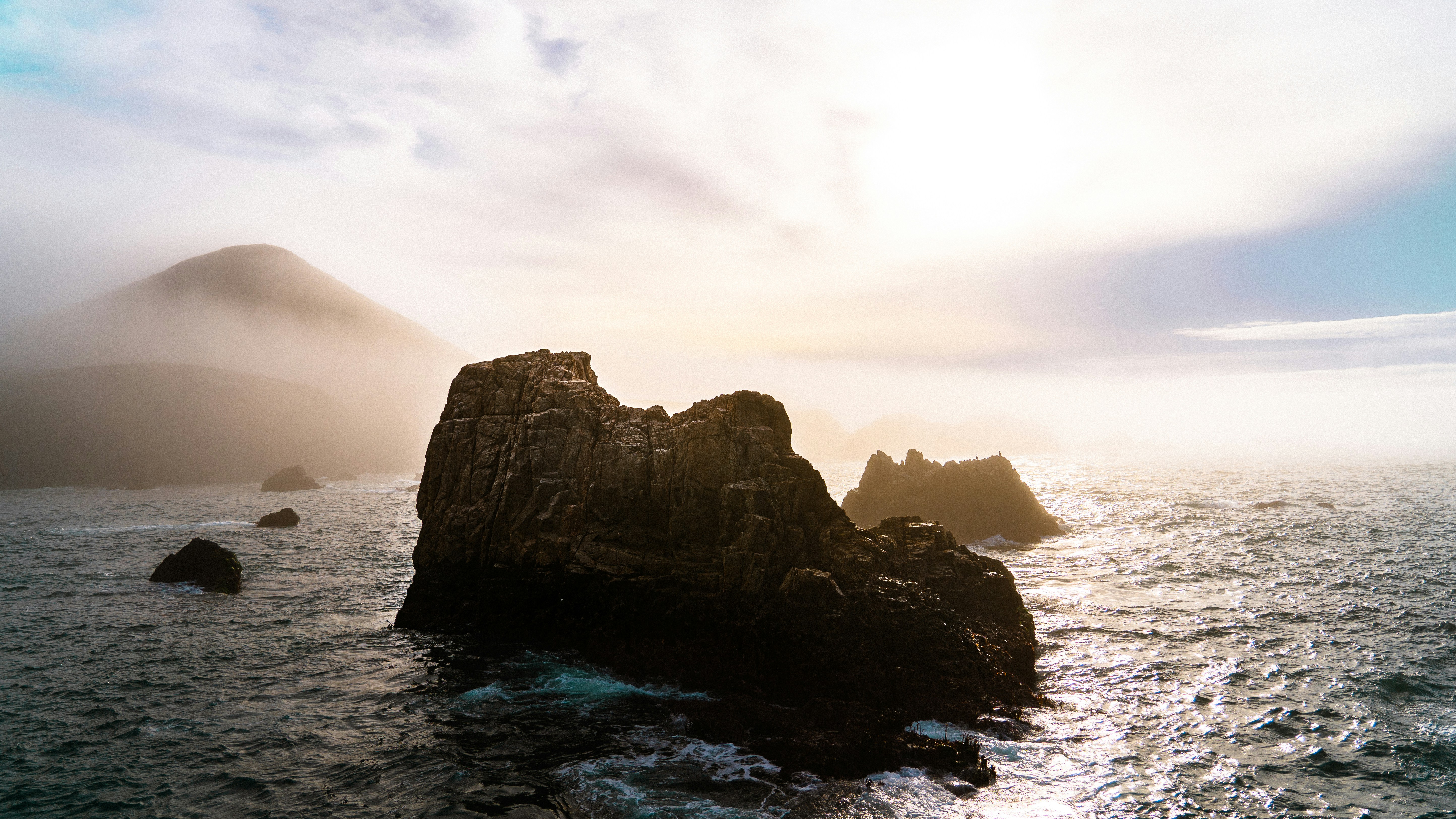 Dawn Rock: Sea Stack Emerges from Morning Mist Over a Quiet Sea