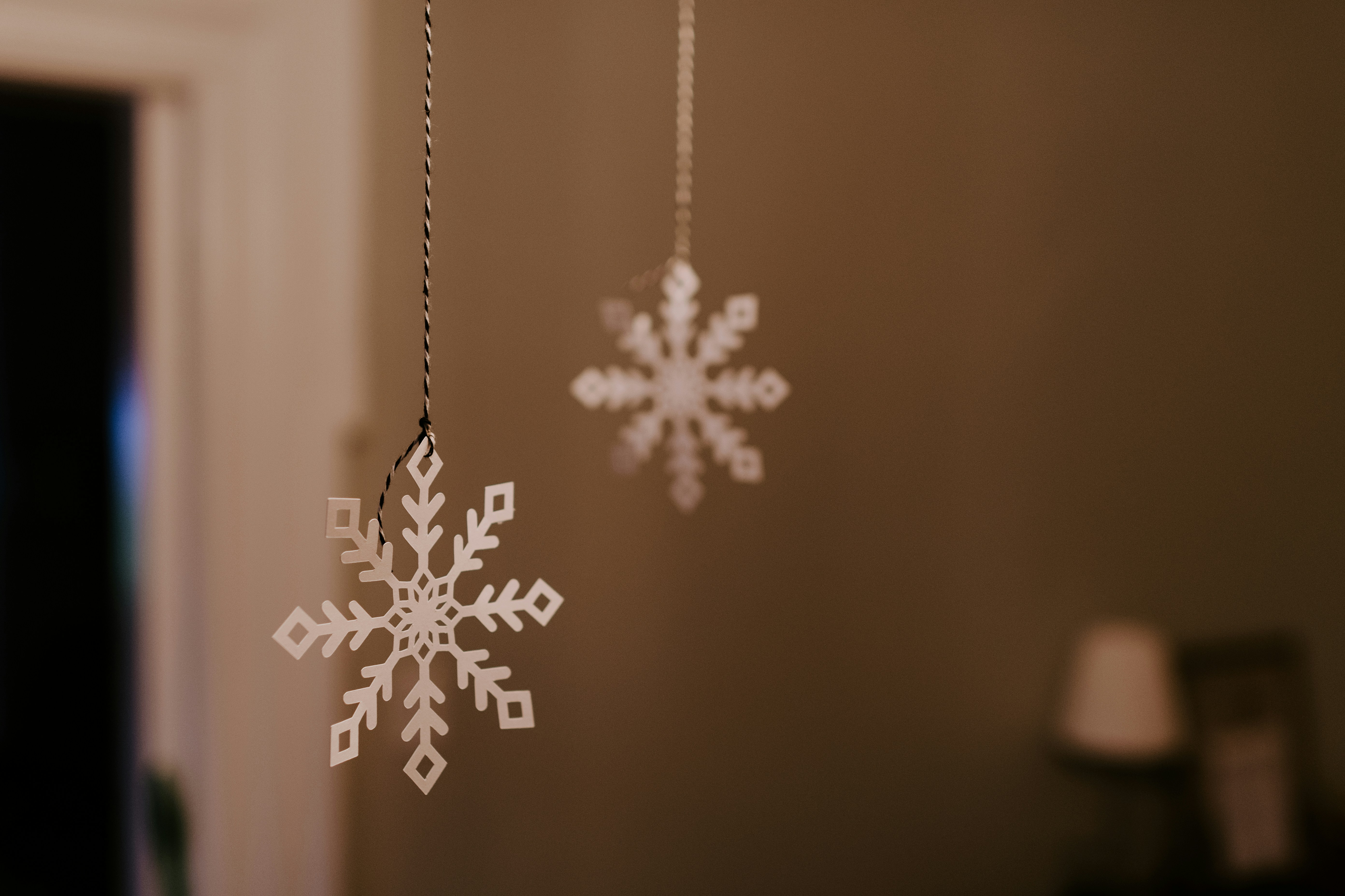 Elegant paper snowflakes suspended against a muted backdrop, creating a serene winter atmosphere.