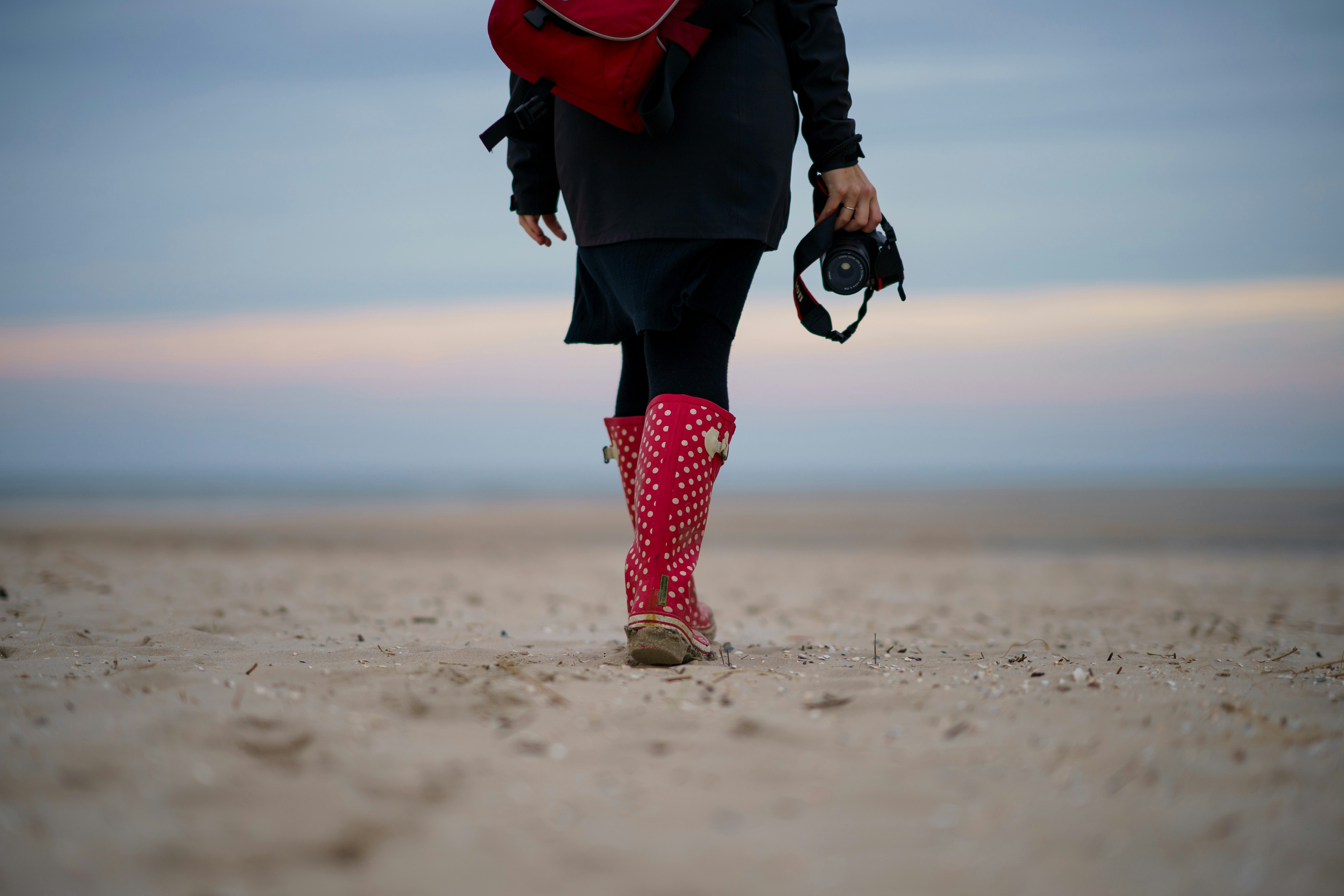 Mid-Strides on the Shore: Red Boots and a Quiet Capture