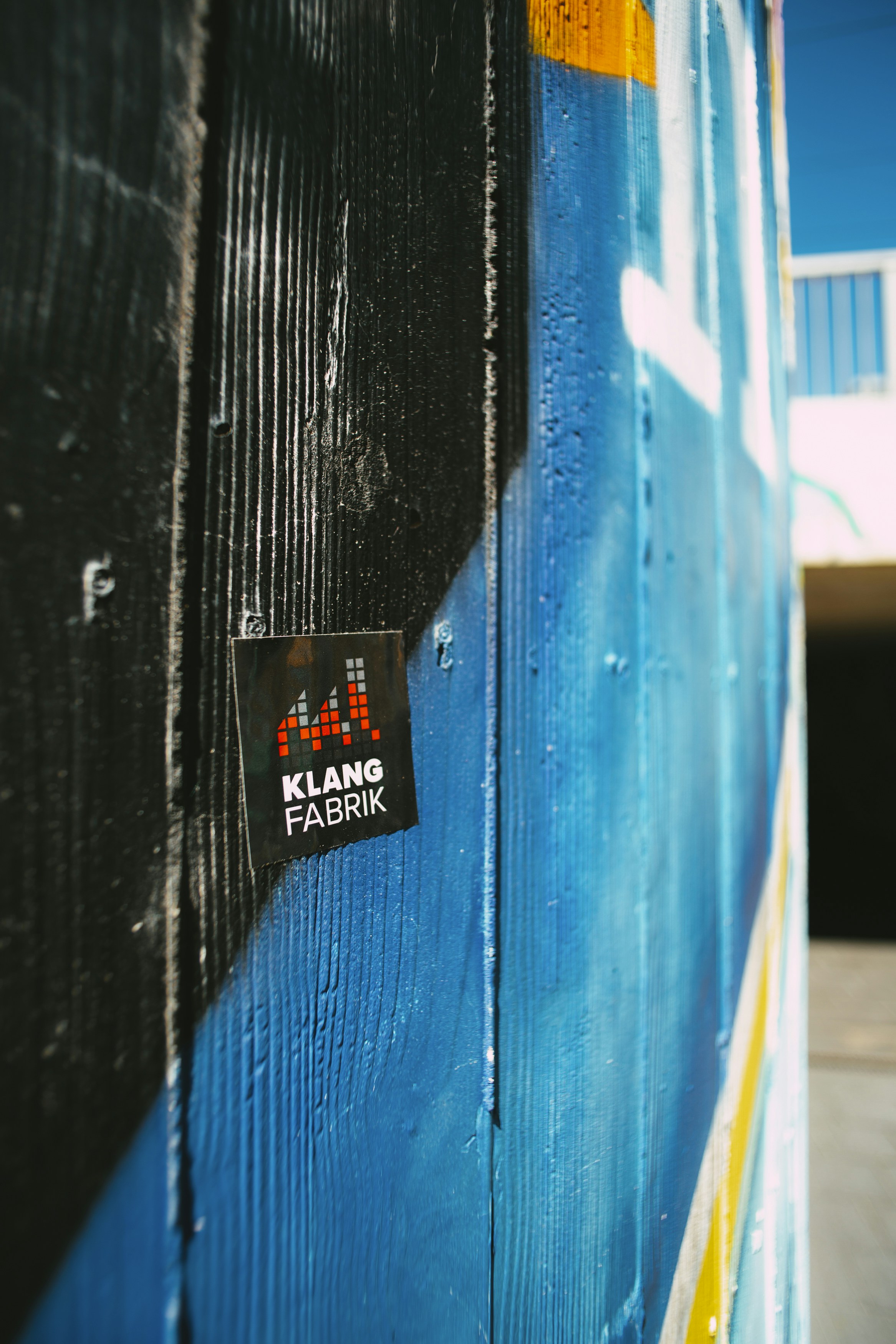 Sticker on Weathered Dock: Klang Fabrik on Blue Planks