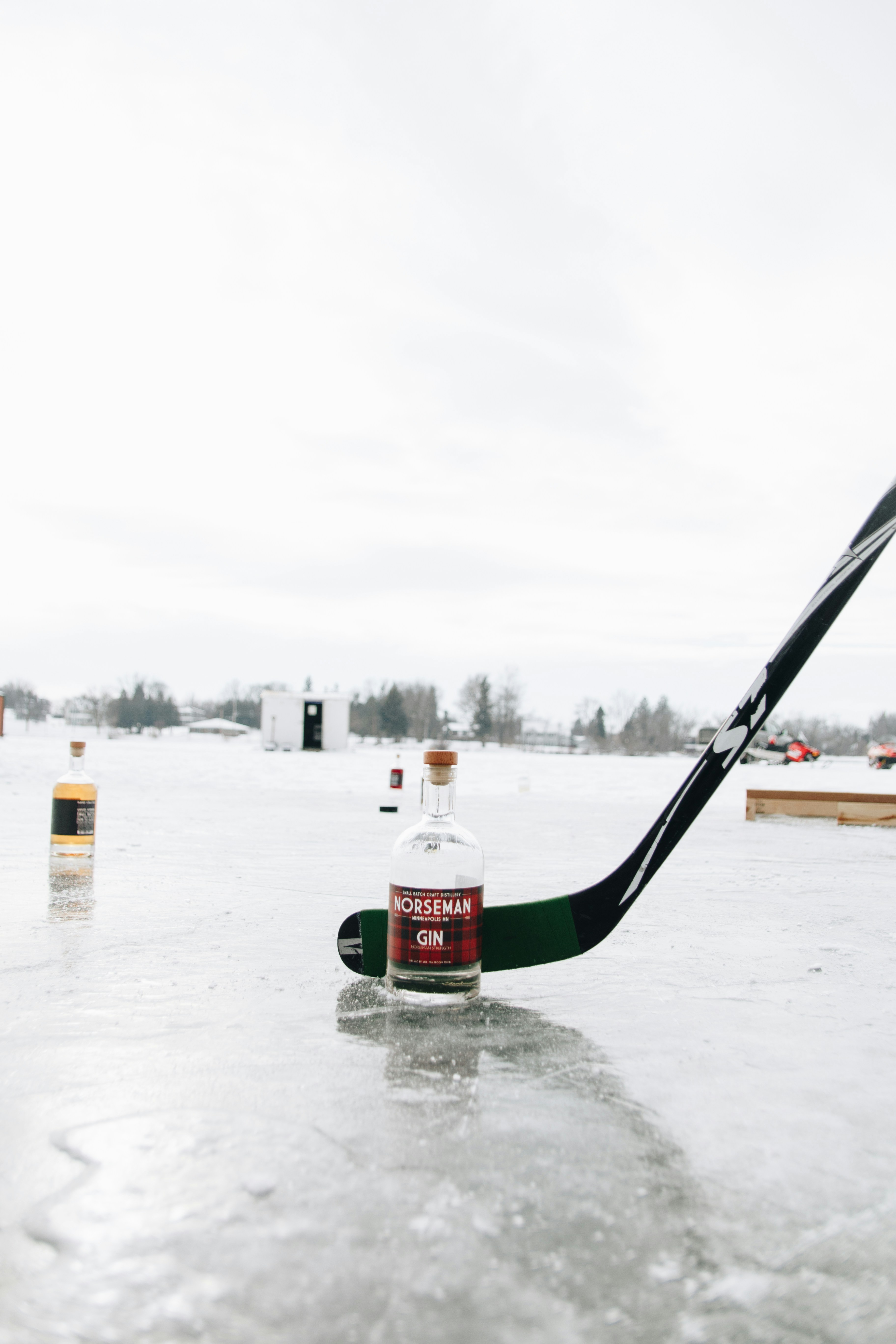 Gin on Ice: A Bottled Moment Beside a Curved Hockey Blade