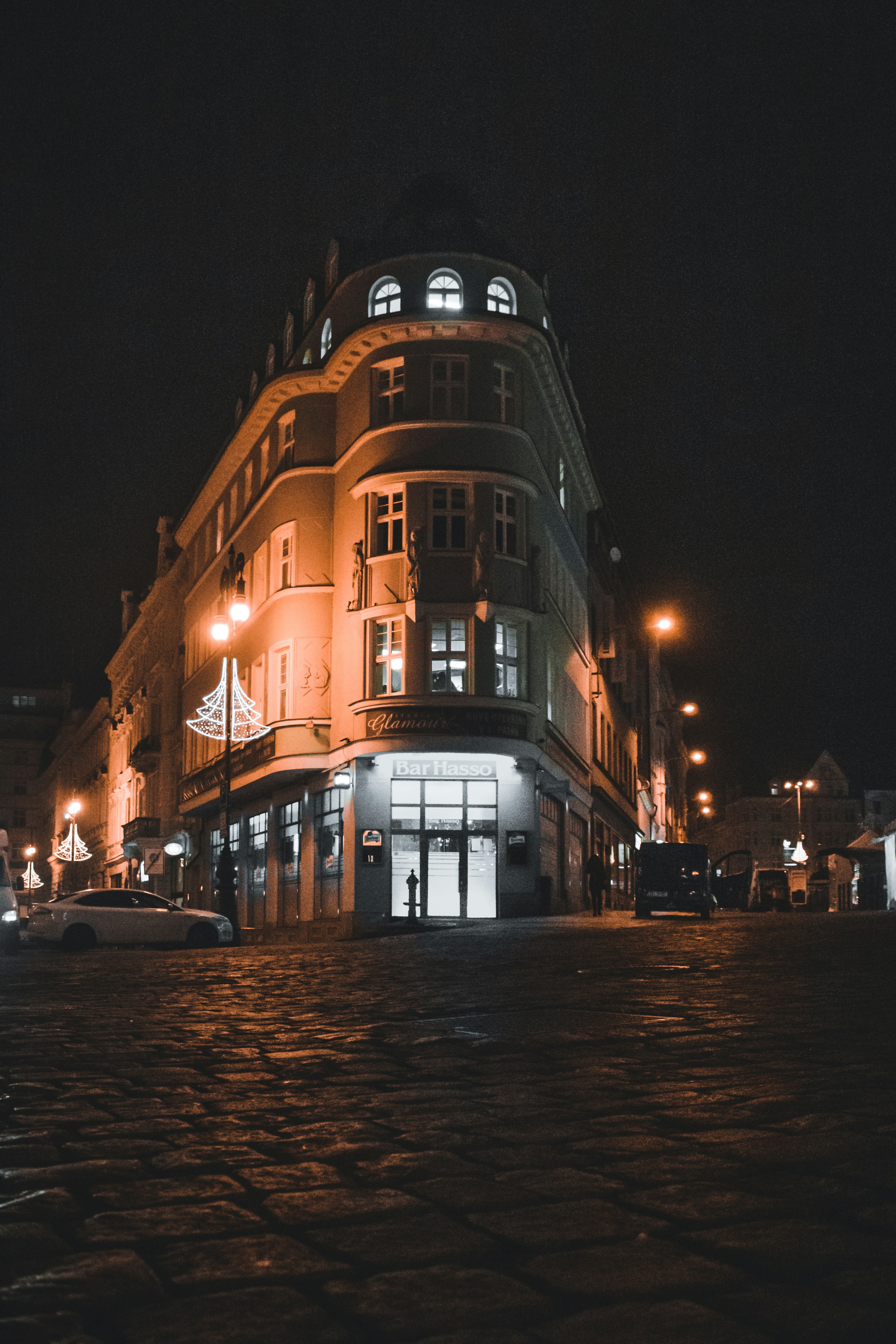 Amber Corner at Night: A Curved-Facade Among Cobblestone Streets