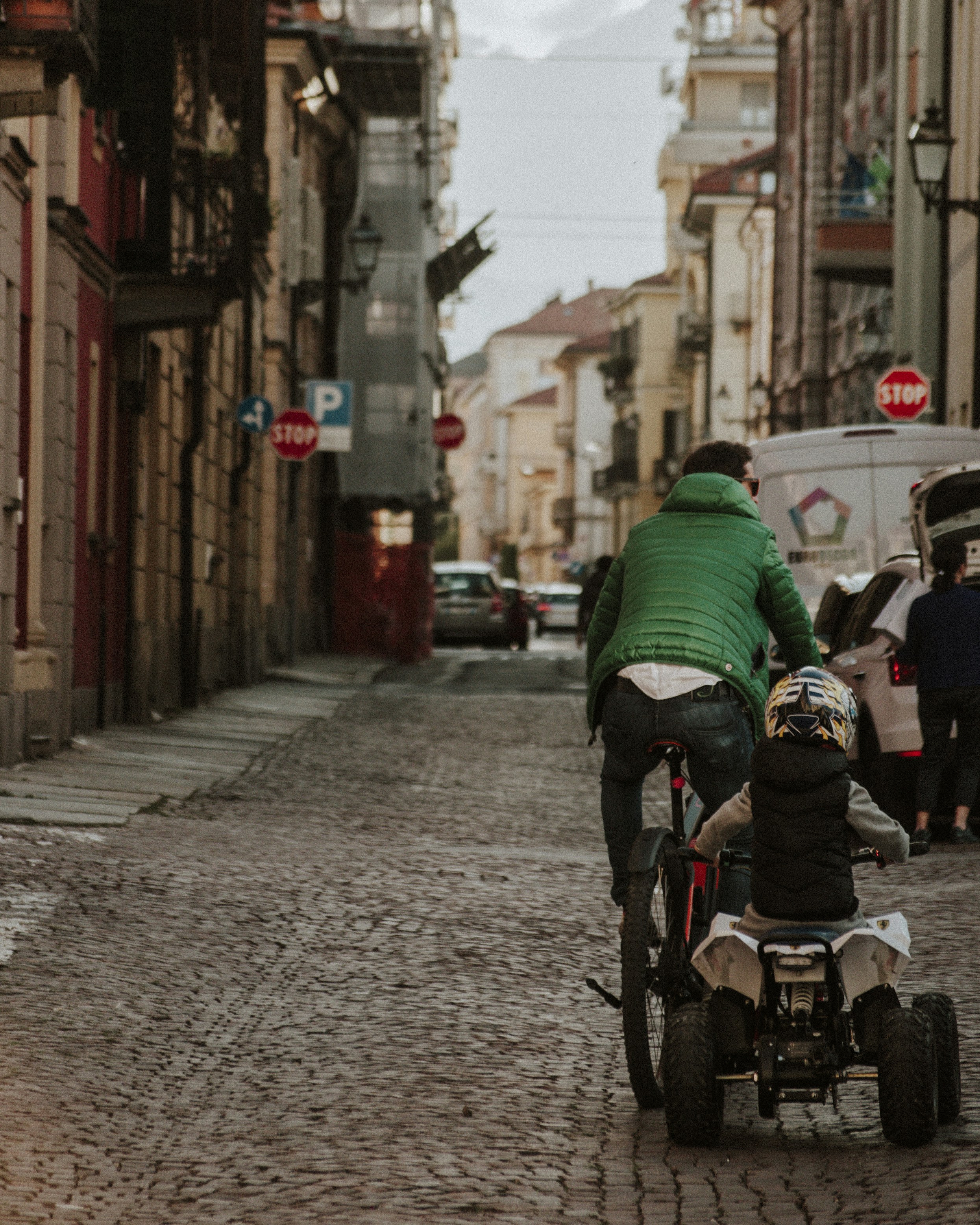 Green Jacket Guiding the Ride Through a Cobblestone Street
