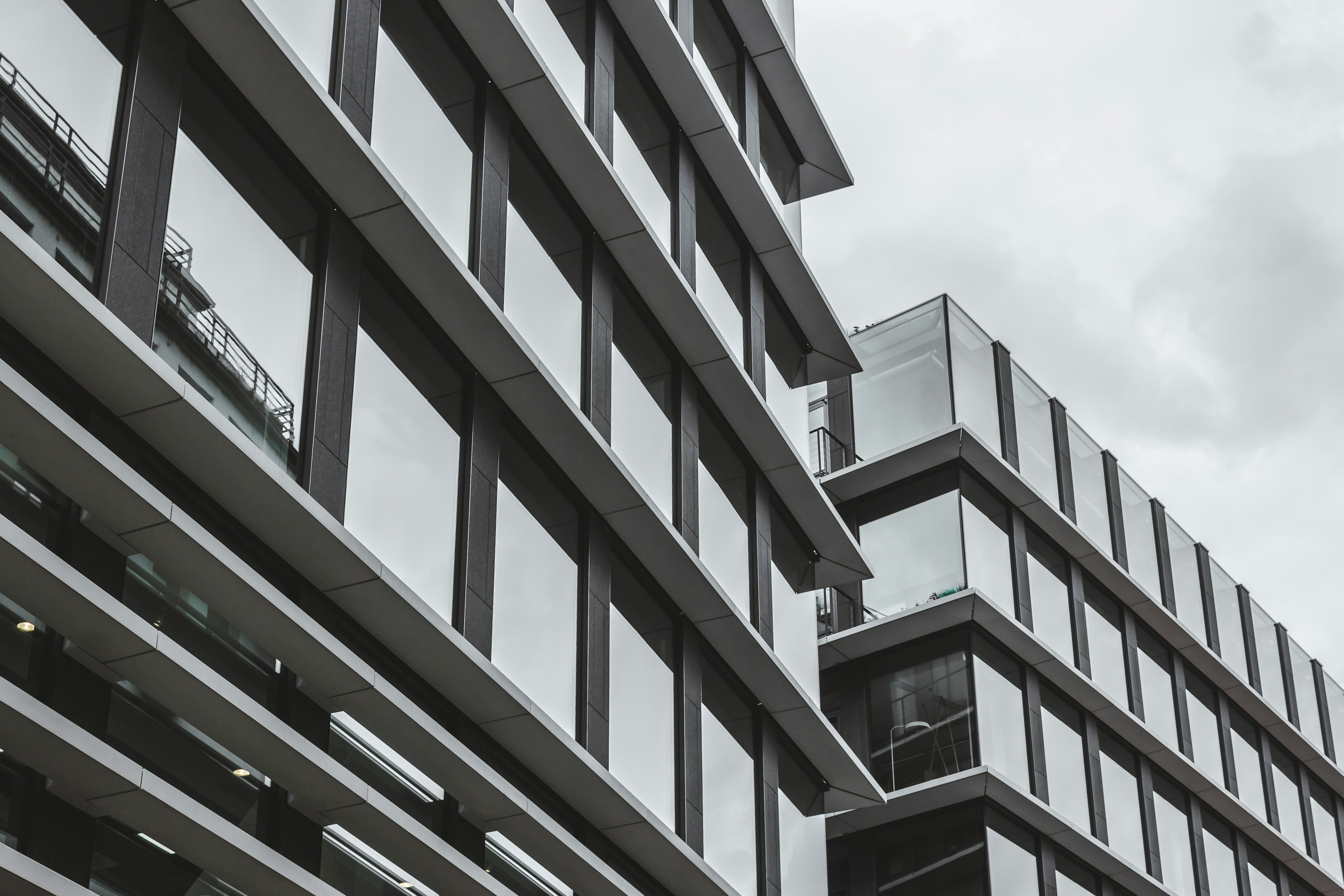 Abstract view of contemporary buildings with glass facades reflecting the sky, showcasing sleek lines and geometric forms.