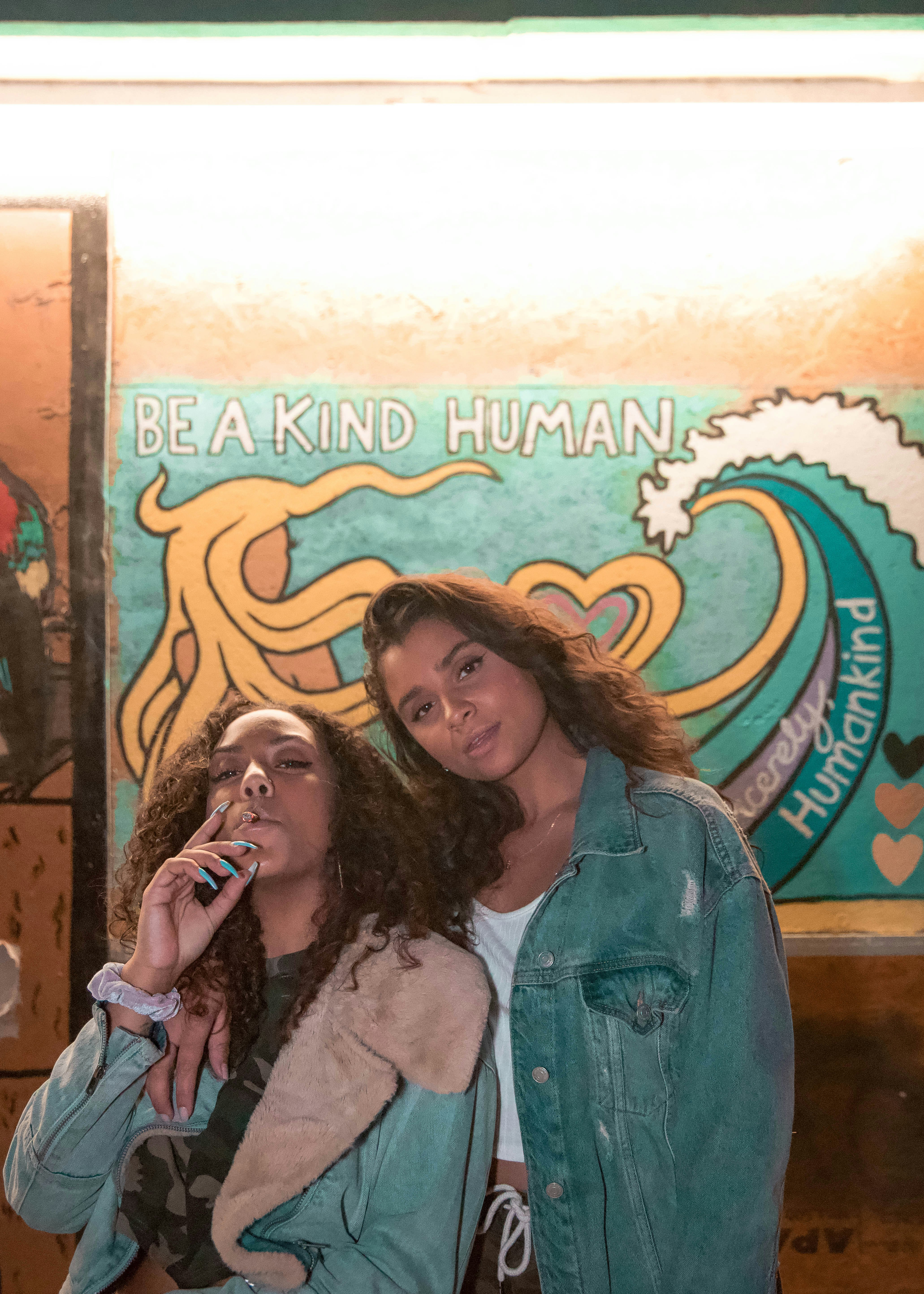 Be Kind Humankind: Denim Duo Before a Vibrant Street Mural