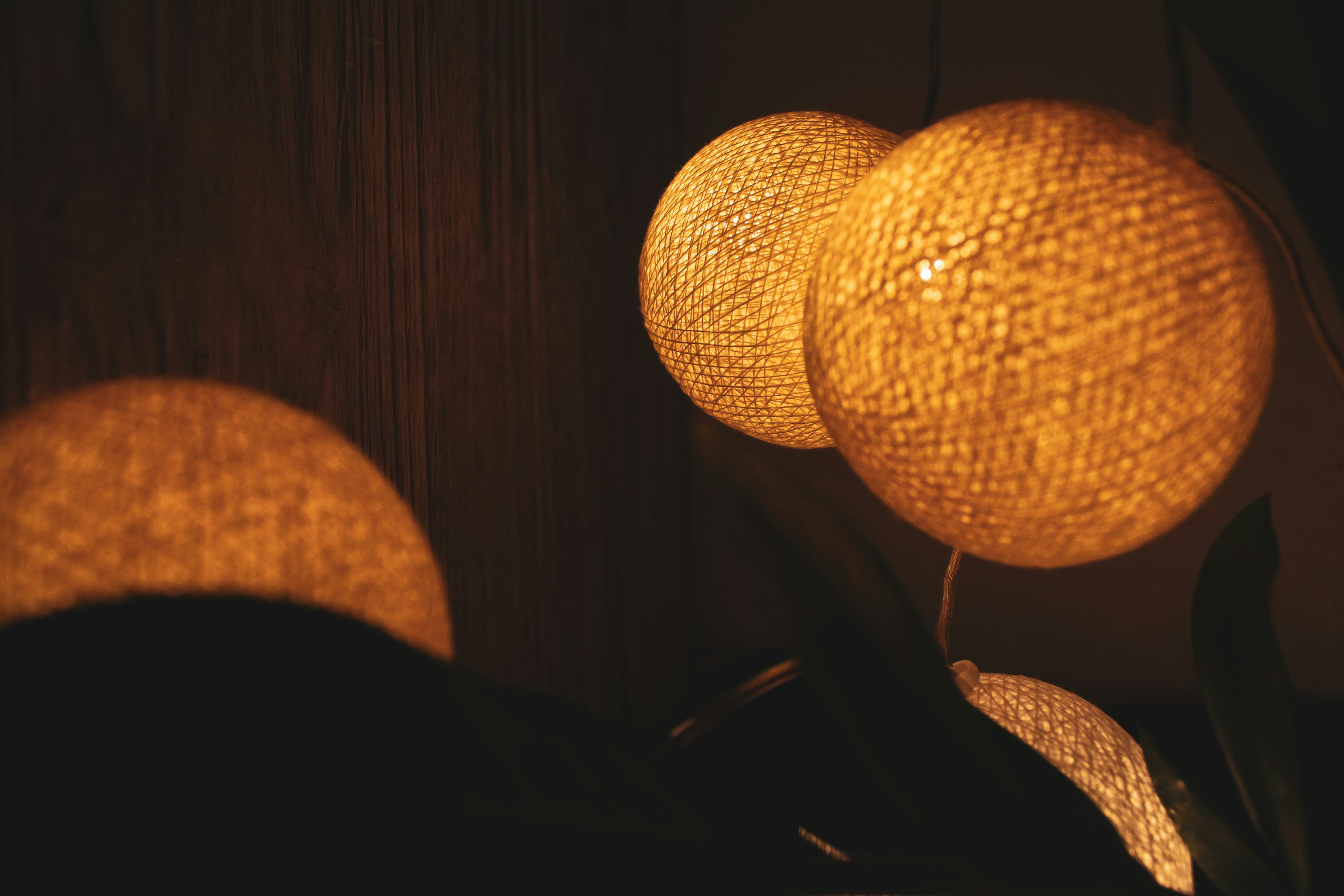 Three textured orbs emit a warm glow against a dark backdrop, creating a cozy atmosphere.