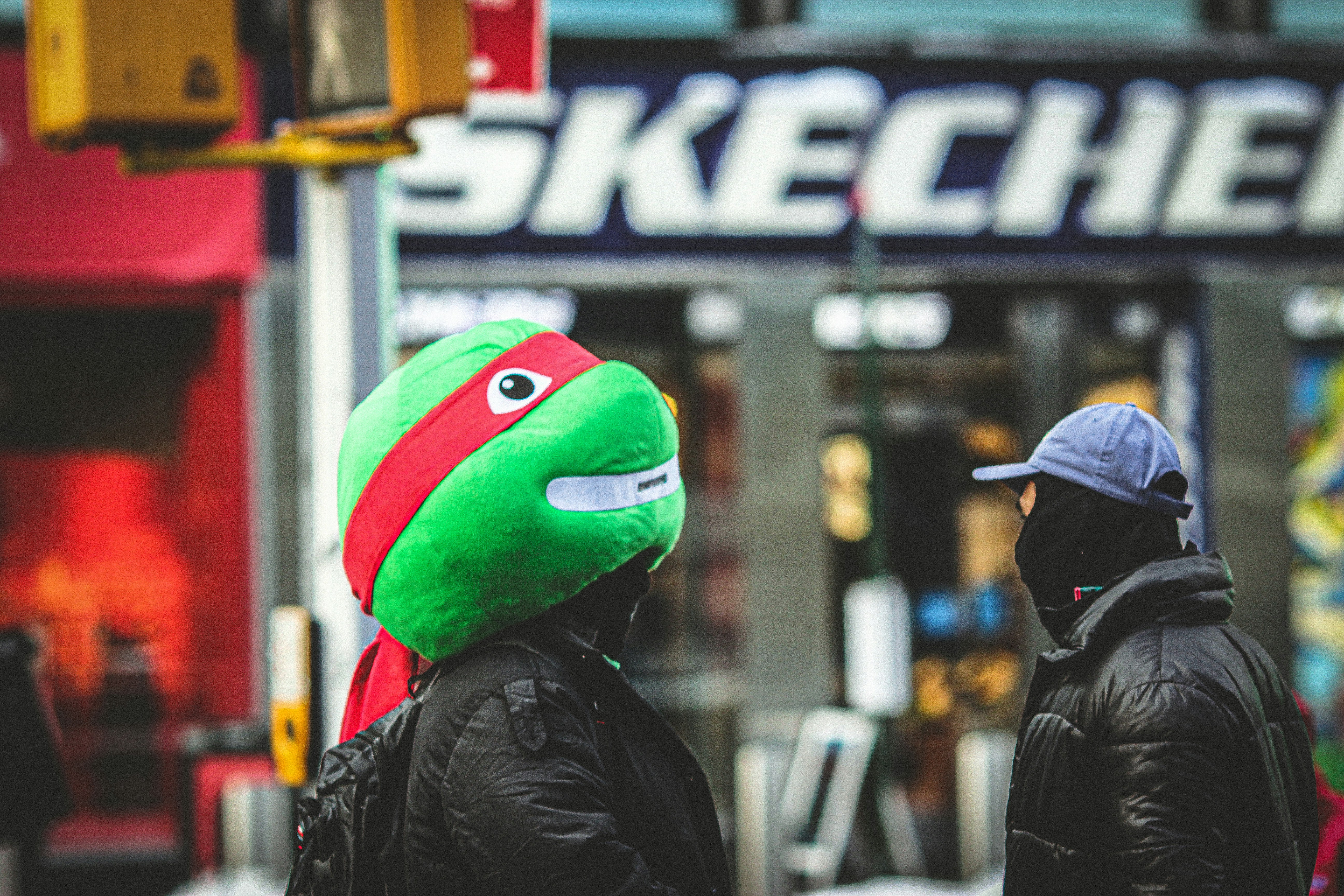 Green Mascot Meets Street Scene Under Skechers Sign