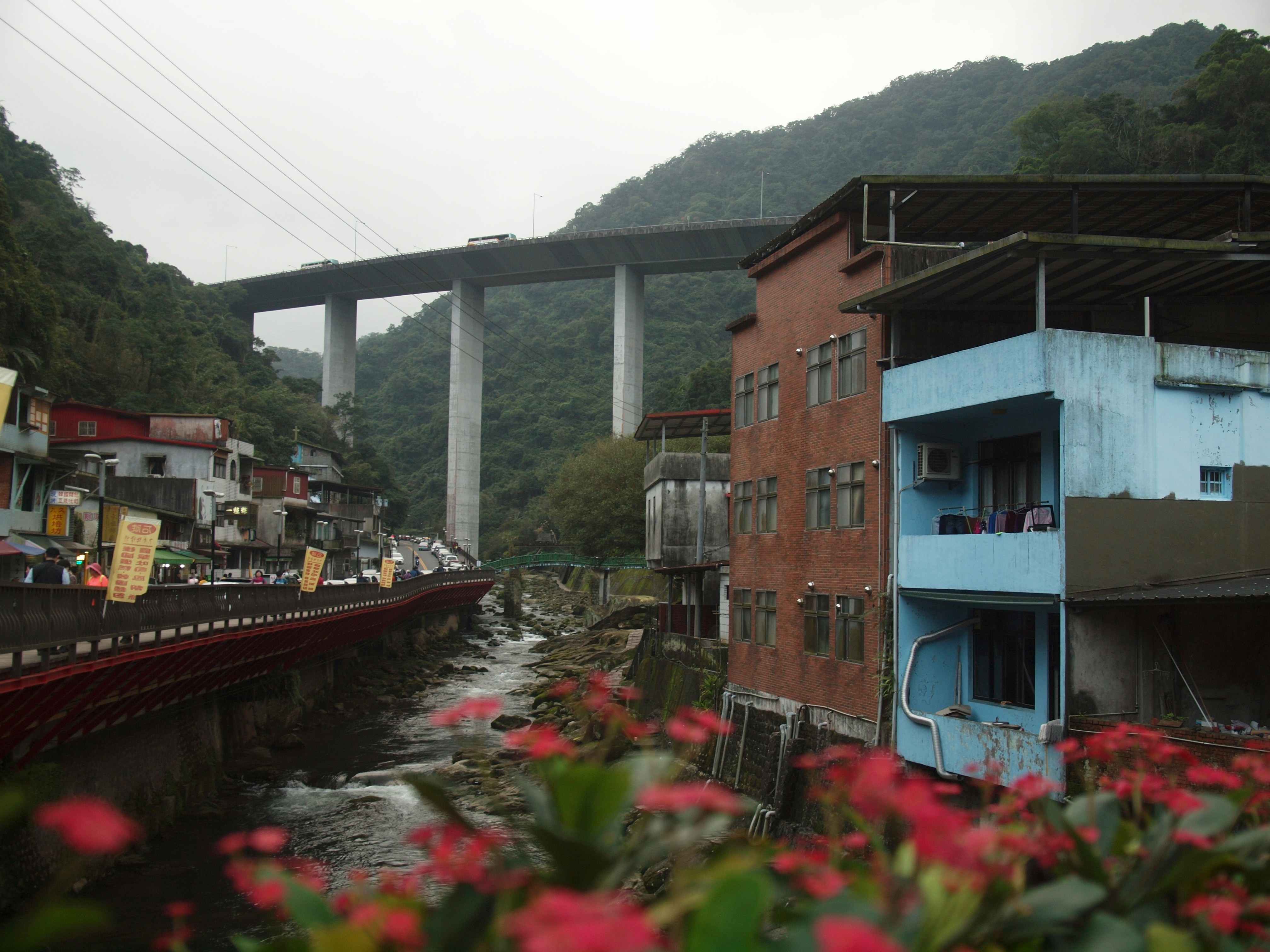 Brown and white concrete building near bridge during daytime photo ...