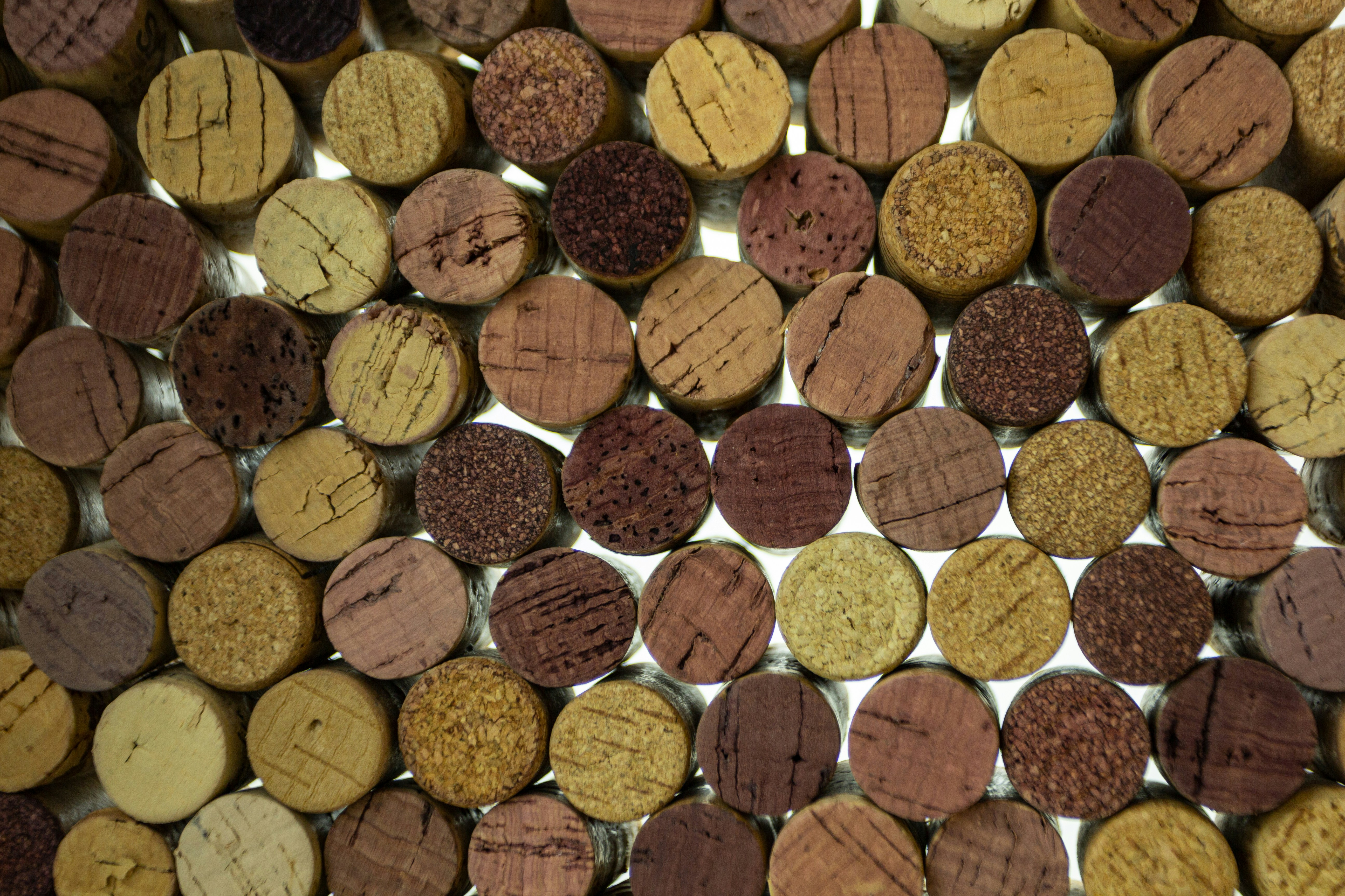 Circular wine corks arranged in a grid pattern showcasing various shades of brown and beige.