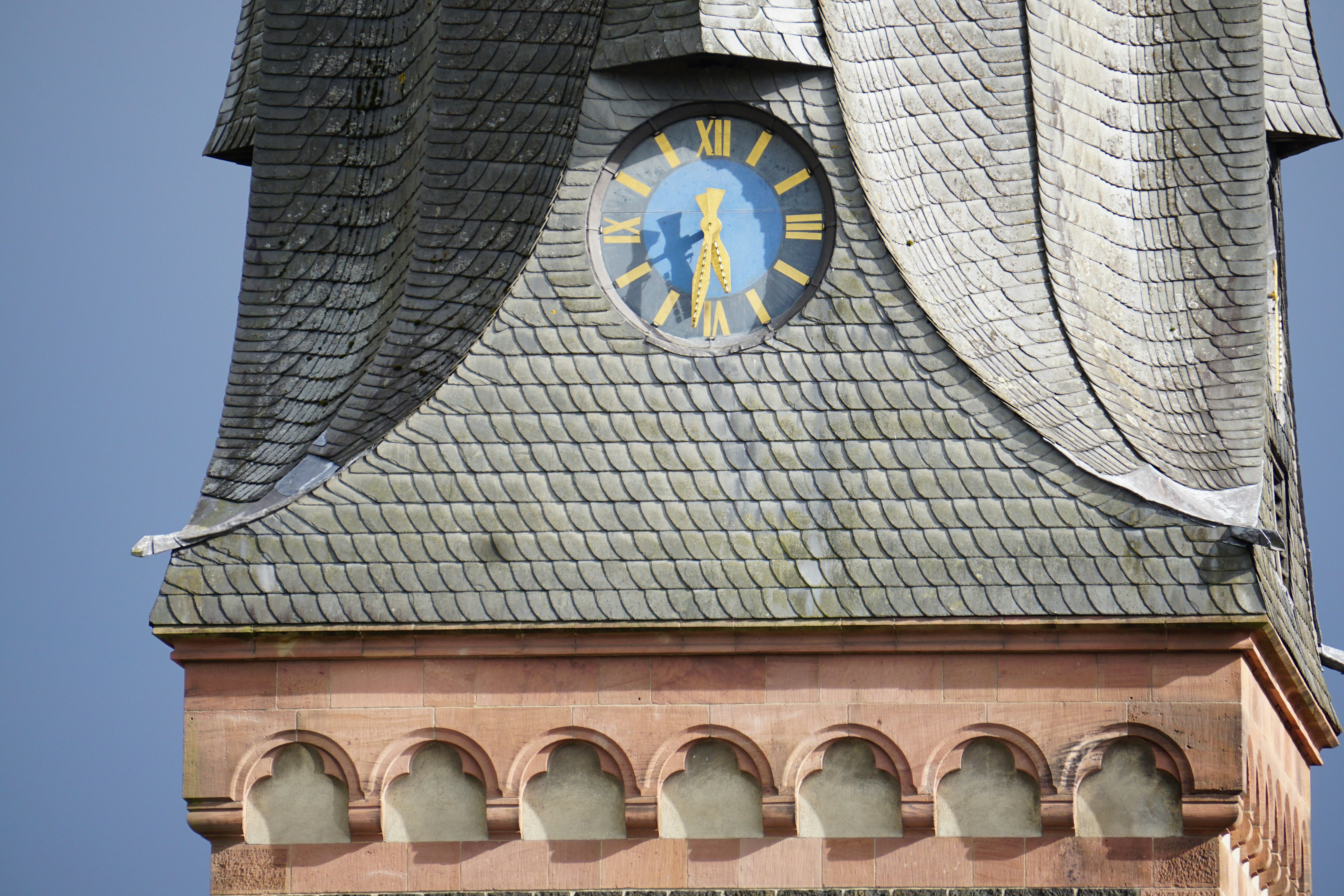 Tower of Time: Clock Face in a Slate Spire Above Brick Arches