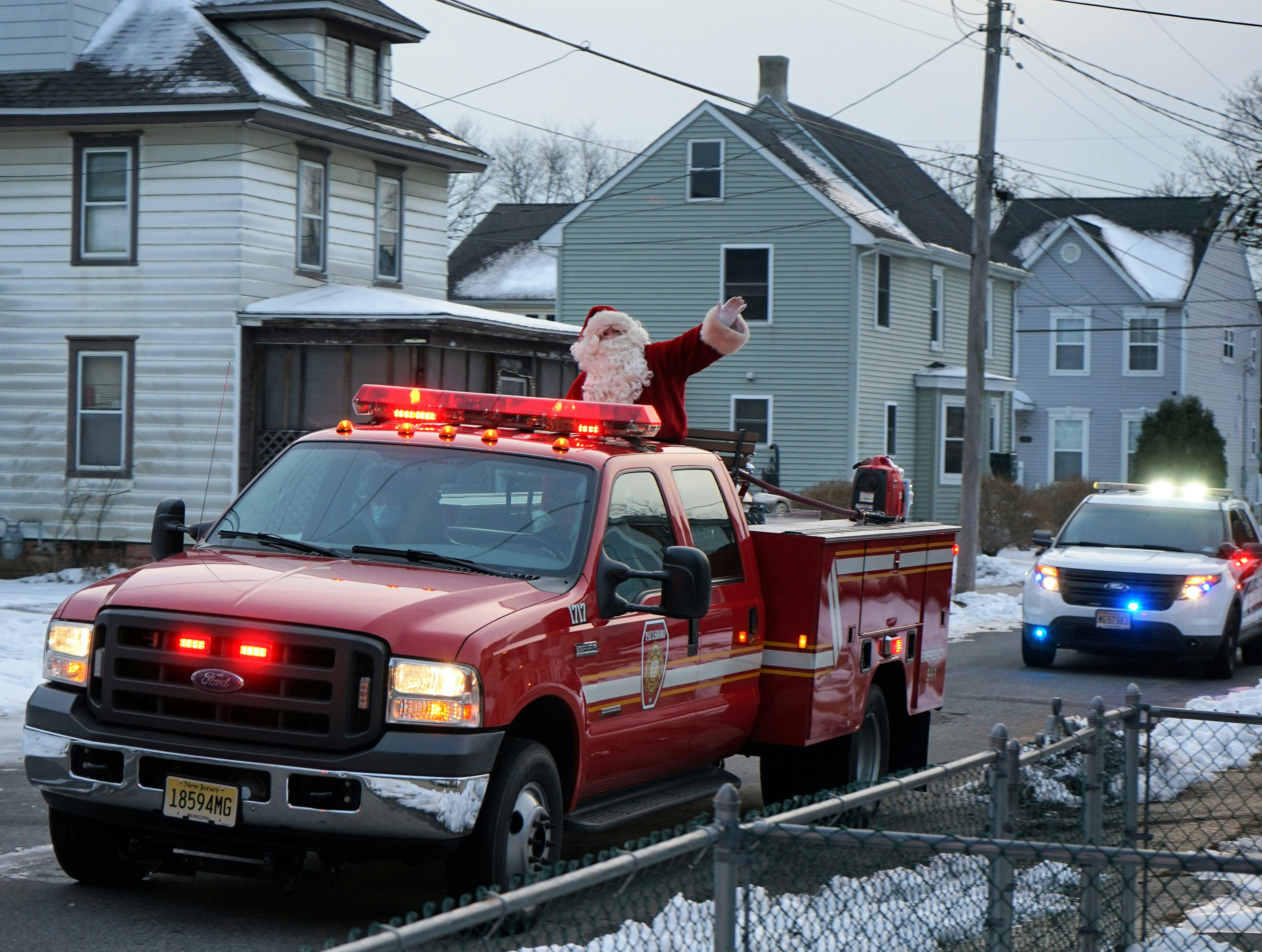 Noel on the Red Engine: Santa Rides Through a Snow-Blanketed Neighborhood