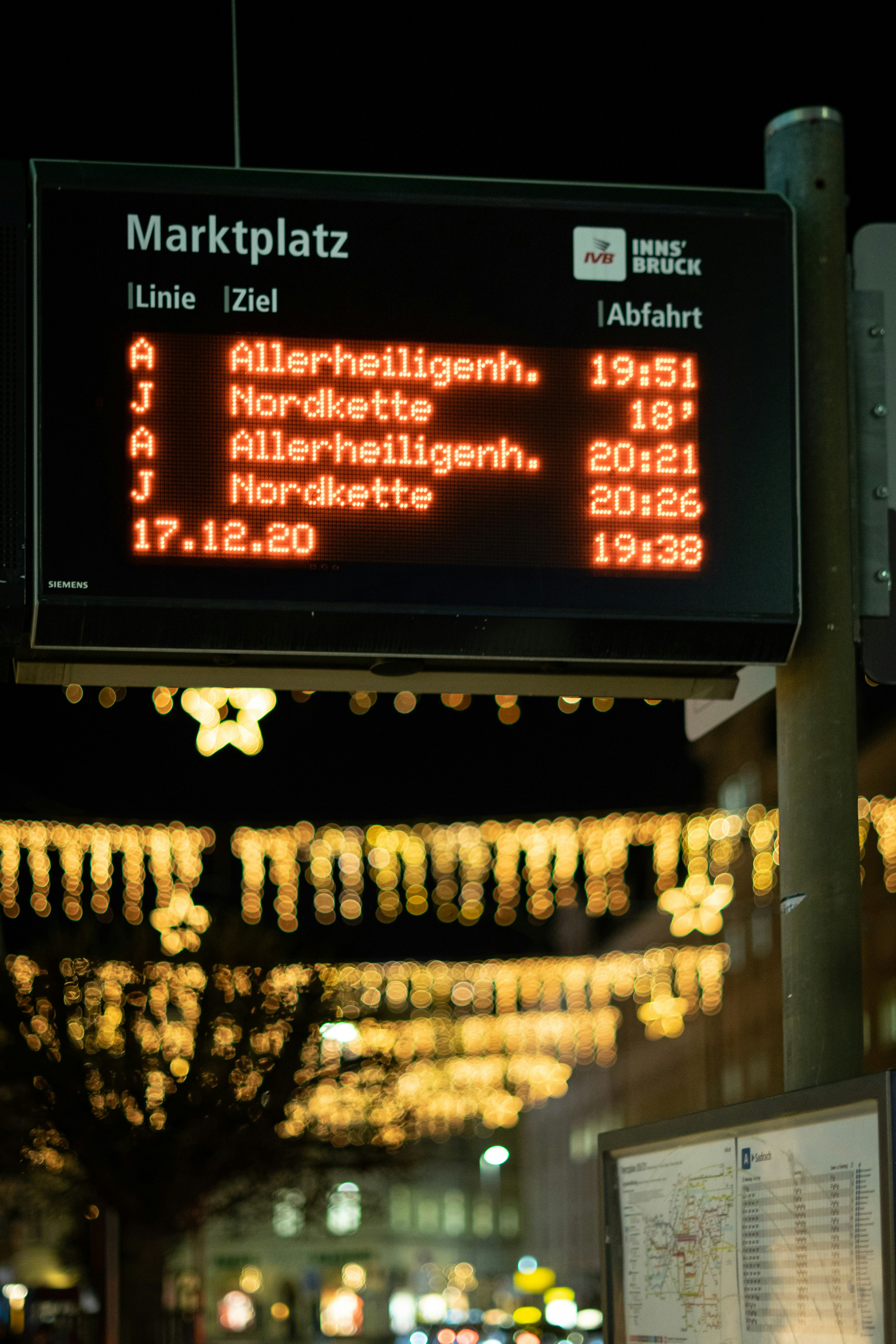 Night at the Bahnhof: A Glowing Departure Sign in Festive Bokeh
