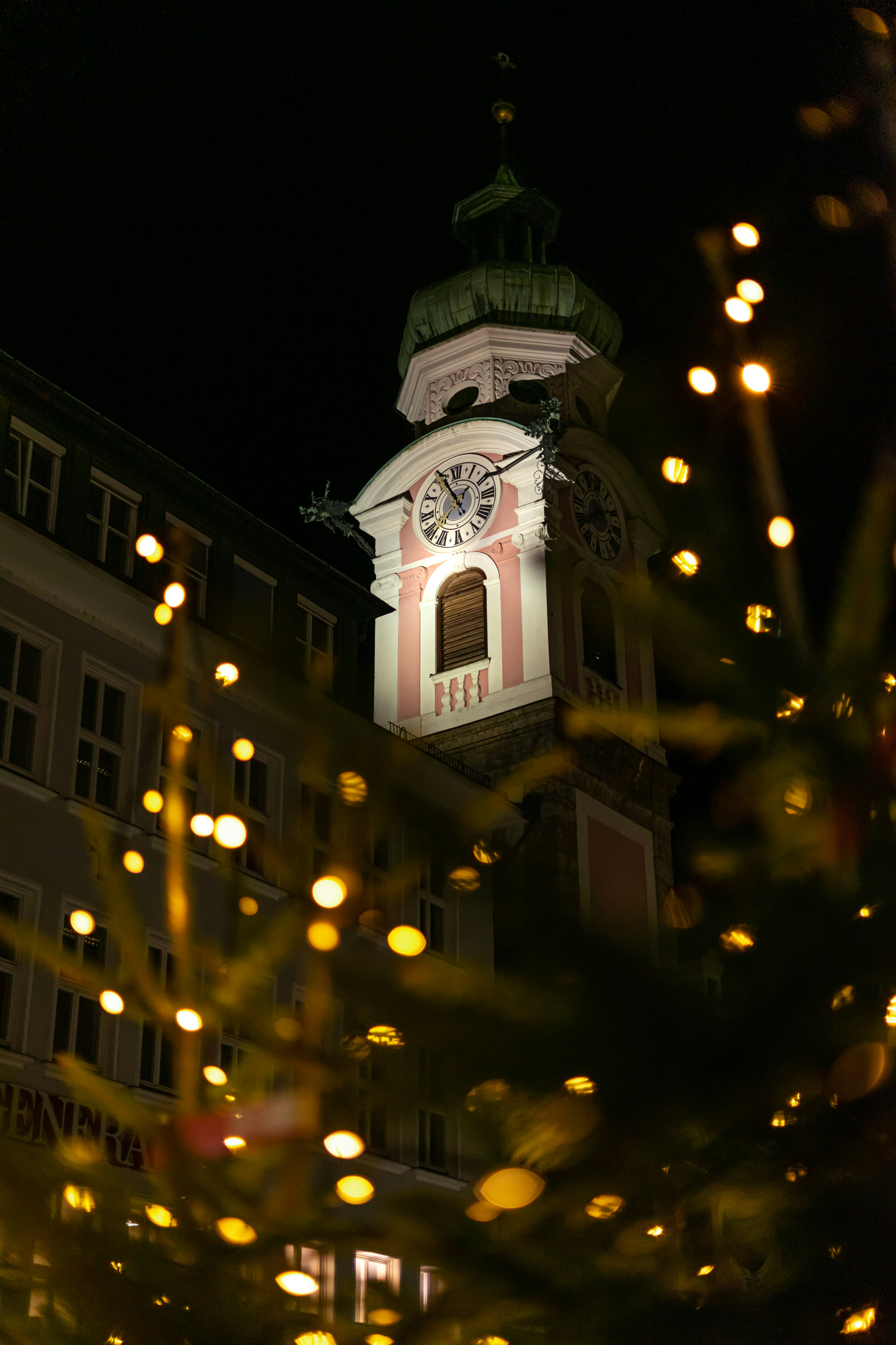 white concrete building with yellow string lights during night time