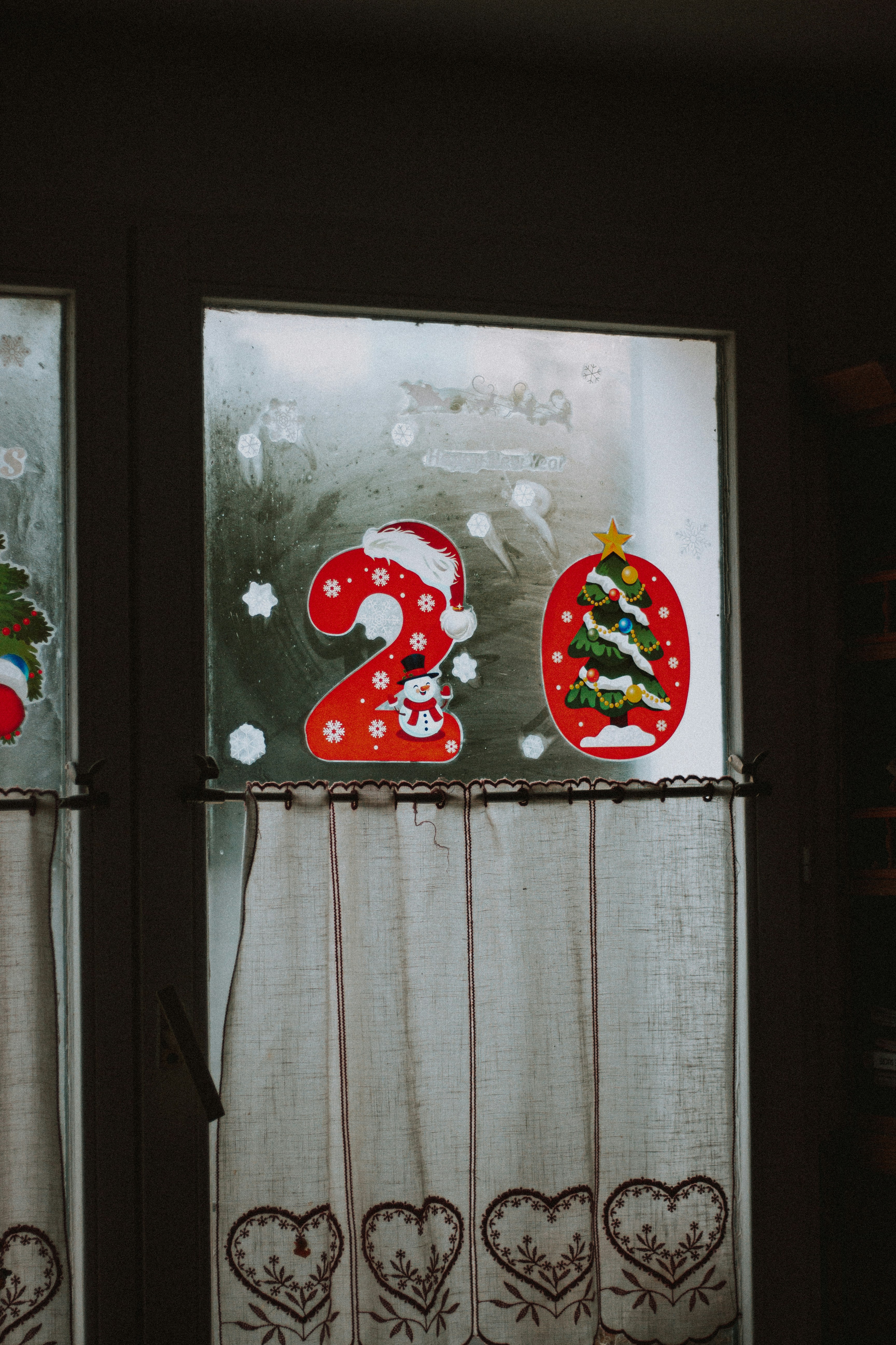 Red 20 on Frosted Glass: A Cozy Christmas Moment Framed by Lace Curtains