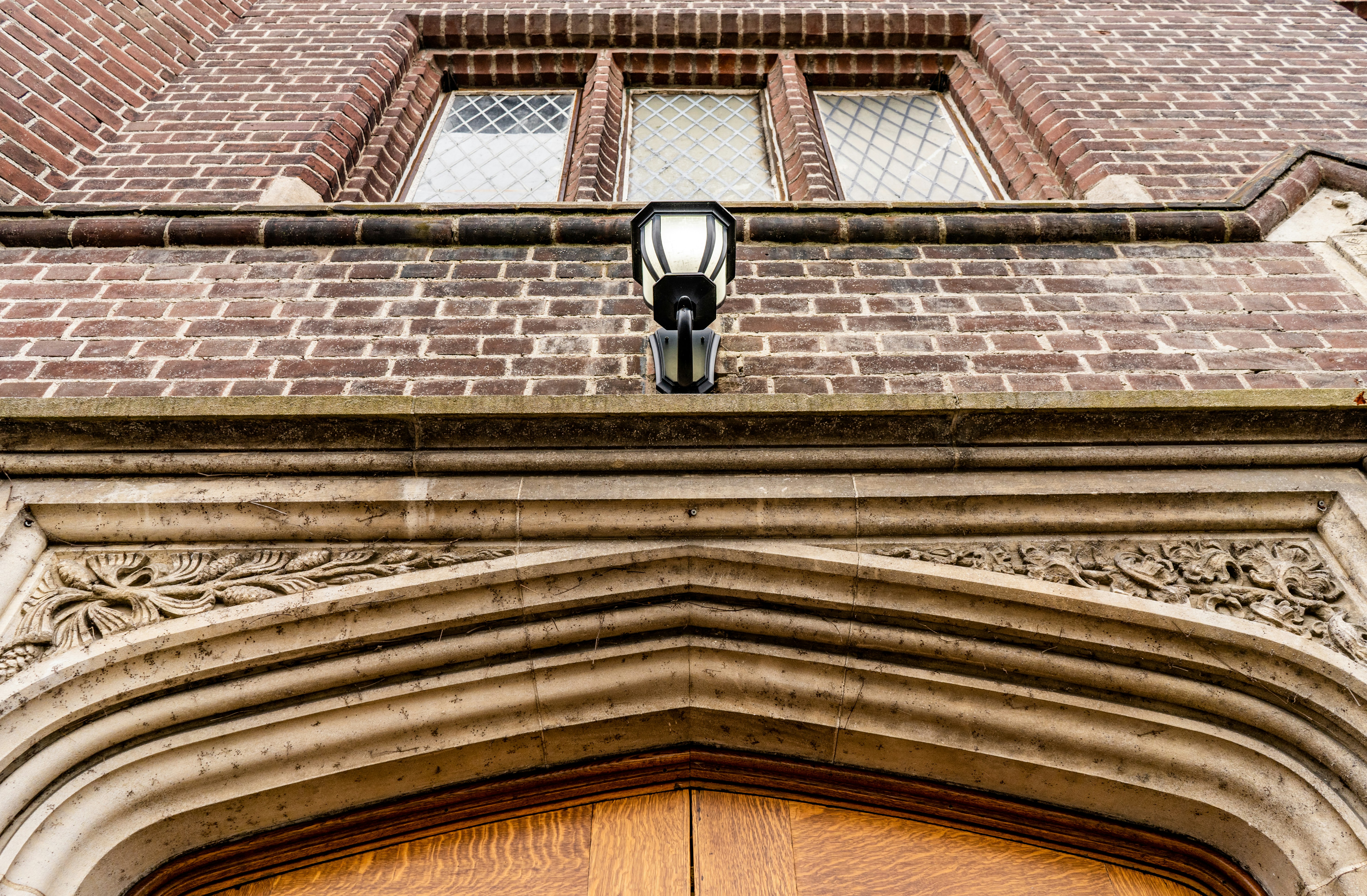 Lantern Above the Carved Arch: A Brick Facade in Quiet Symmetry