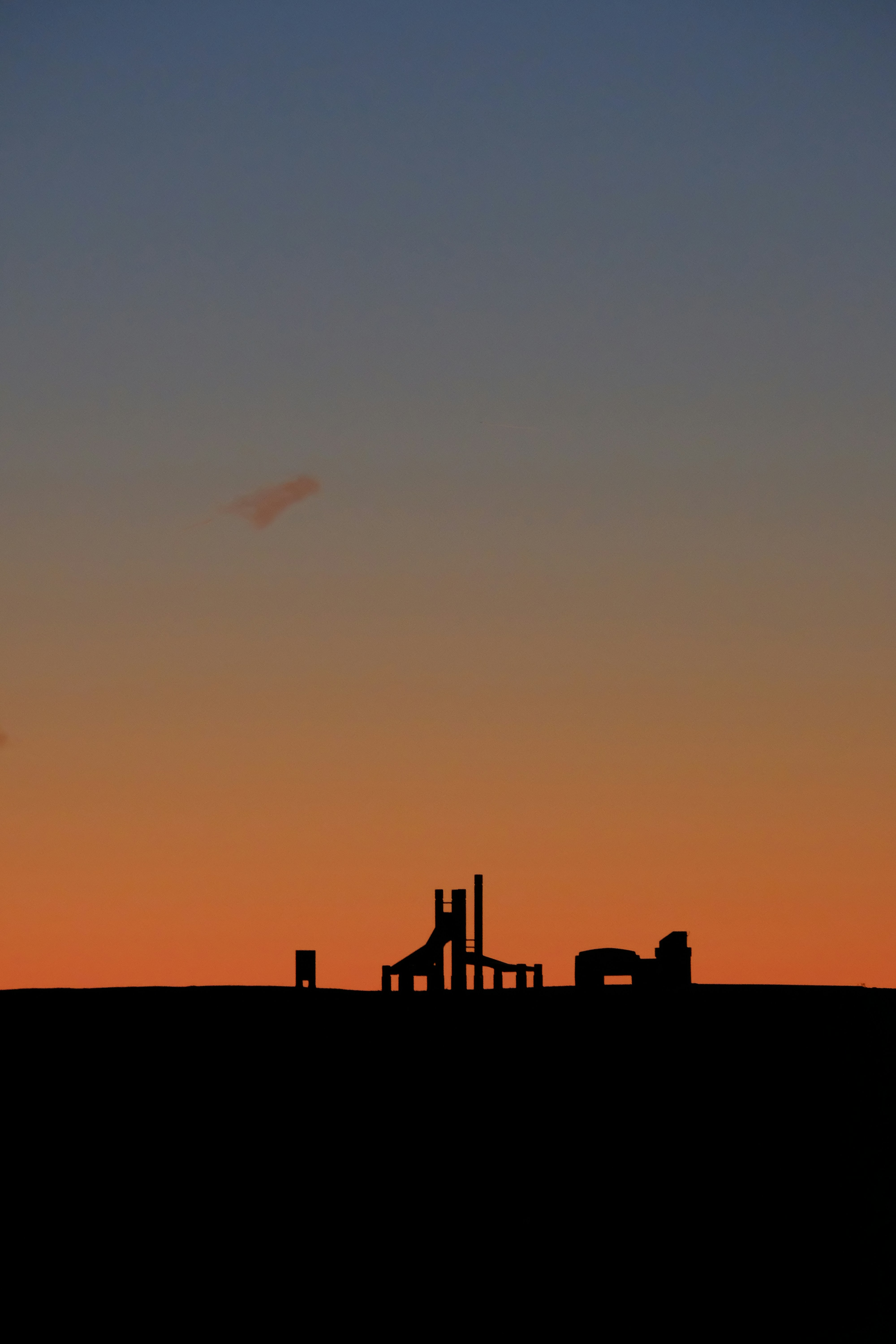 silhouette of people standing on bridge during sunset