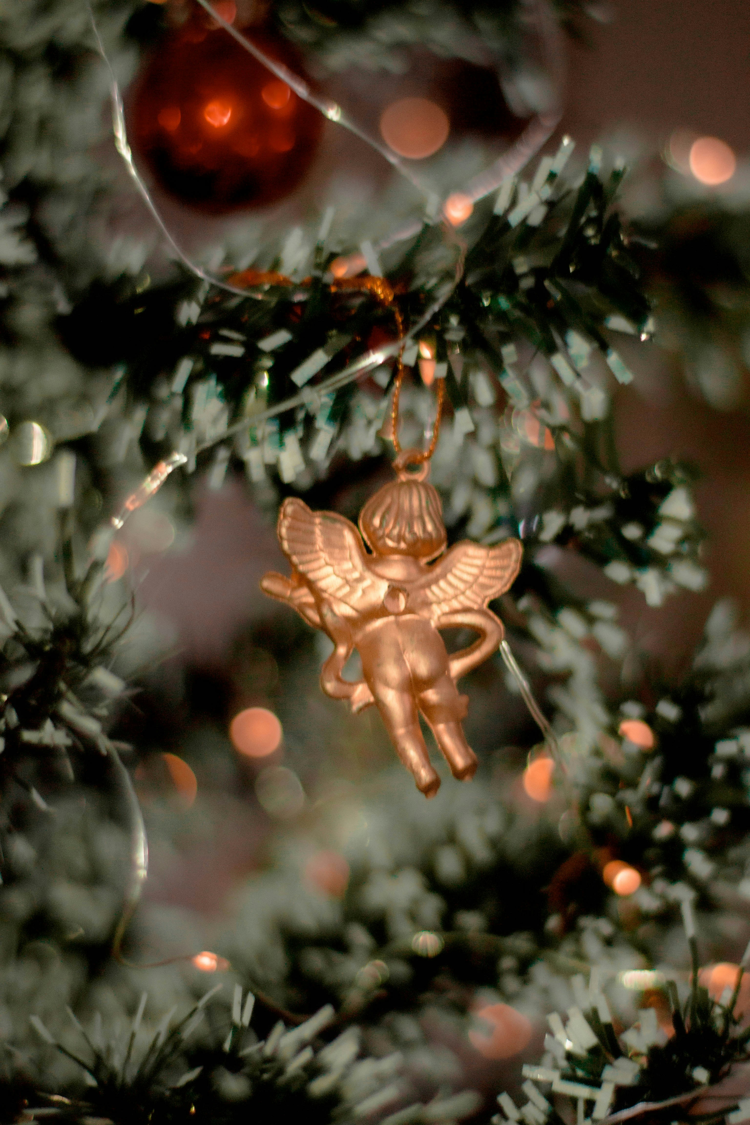 Copper Angel Ornament Floating Amid Warm Christmas Bokeh