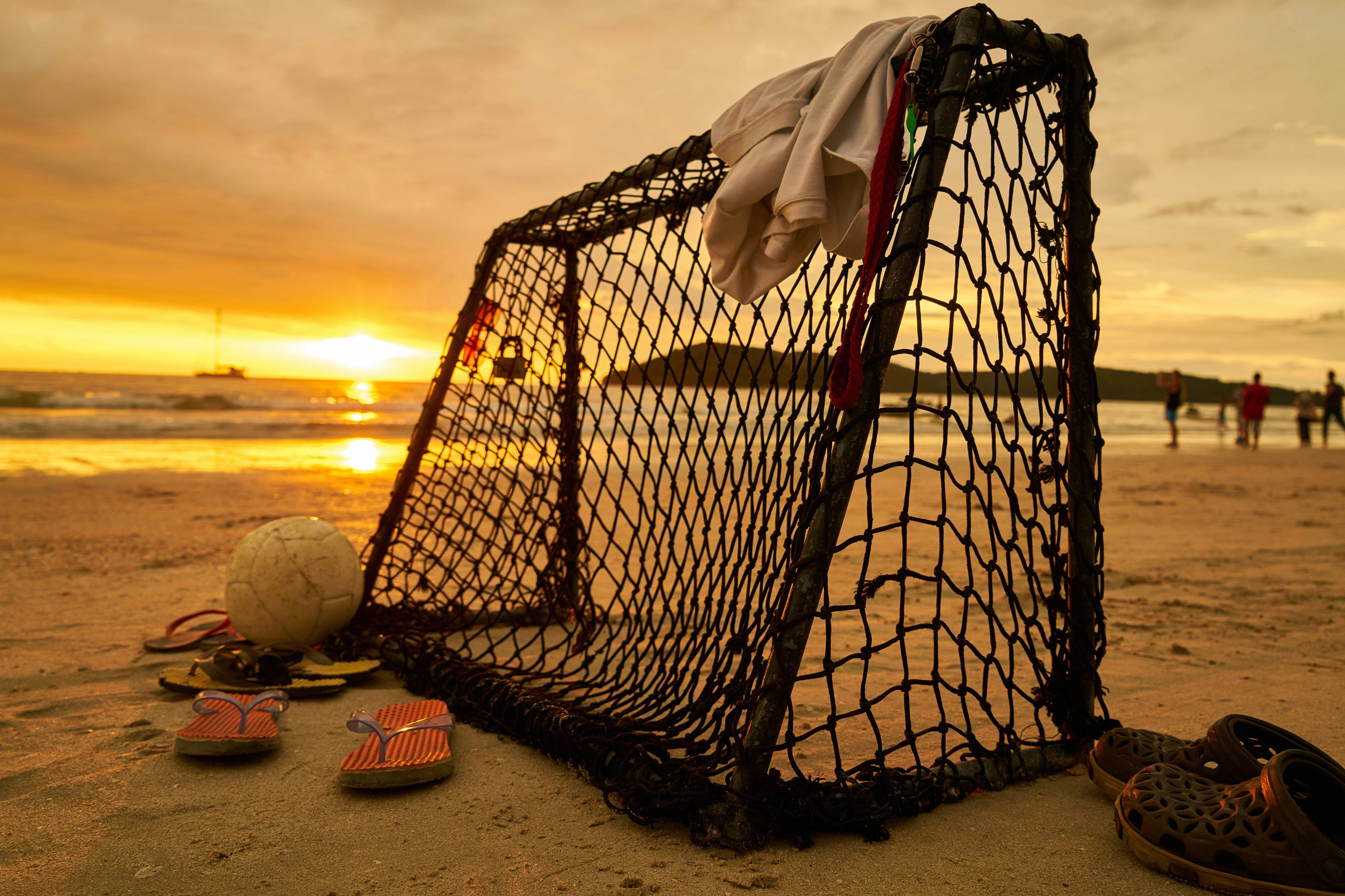 Golden Hour Net at the Shore: A Worn Soccer Goal Framed by Dusk
