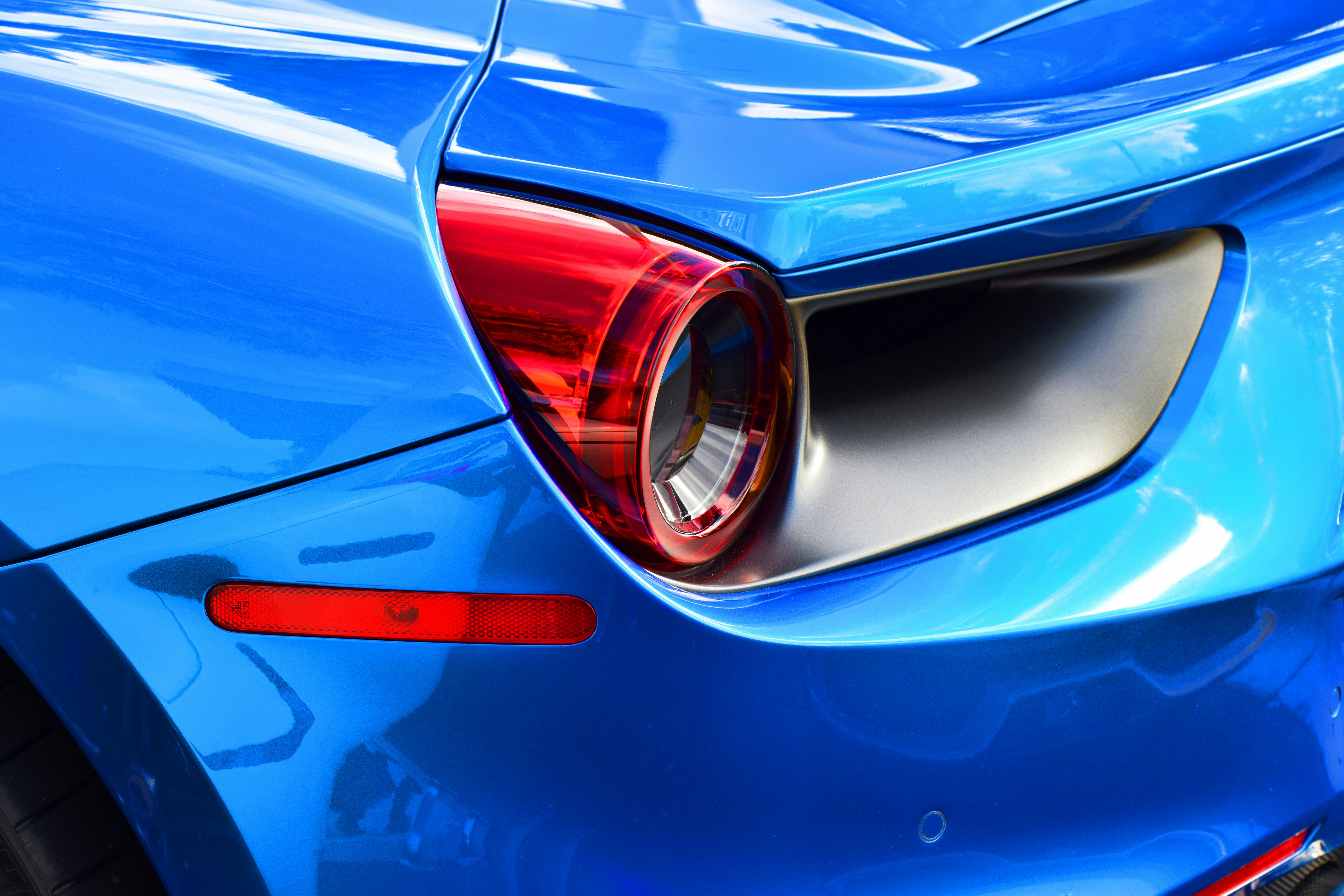 Electric Blue Tail: A Car’s Curves and Red Halo