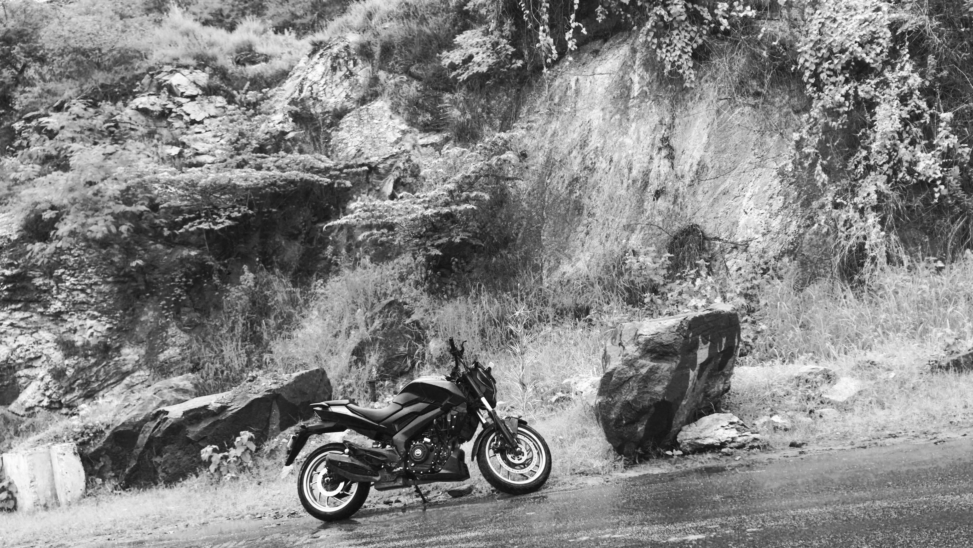 Grayscale photo of motorcycle parked beside rock formation photo – Free ...