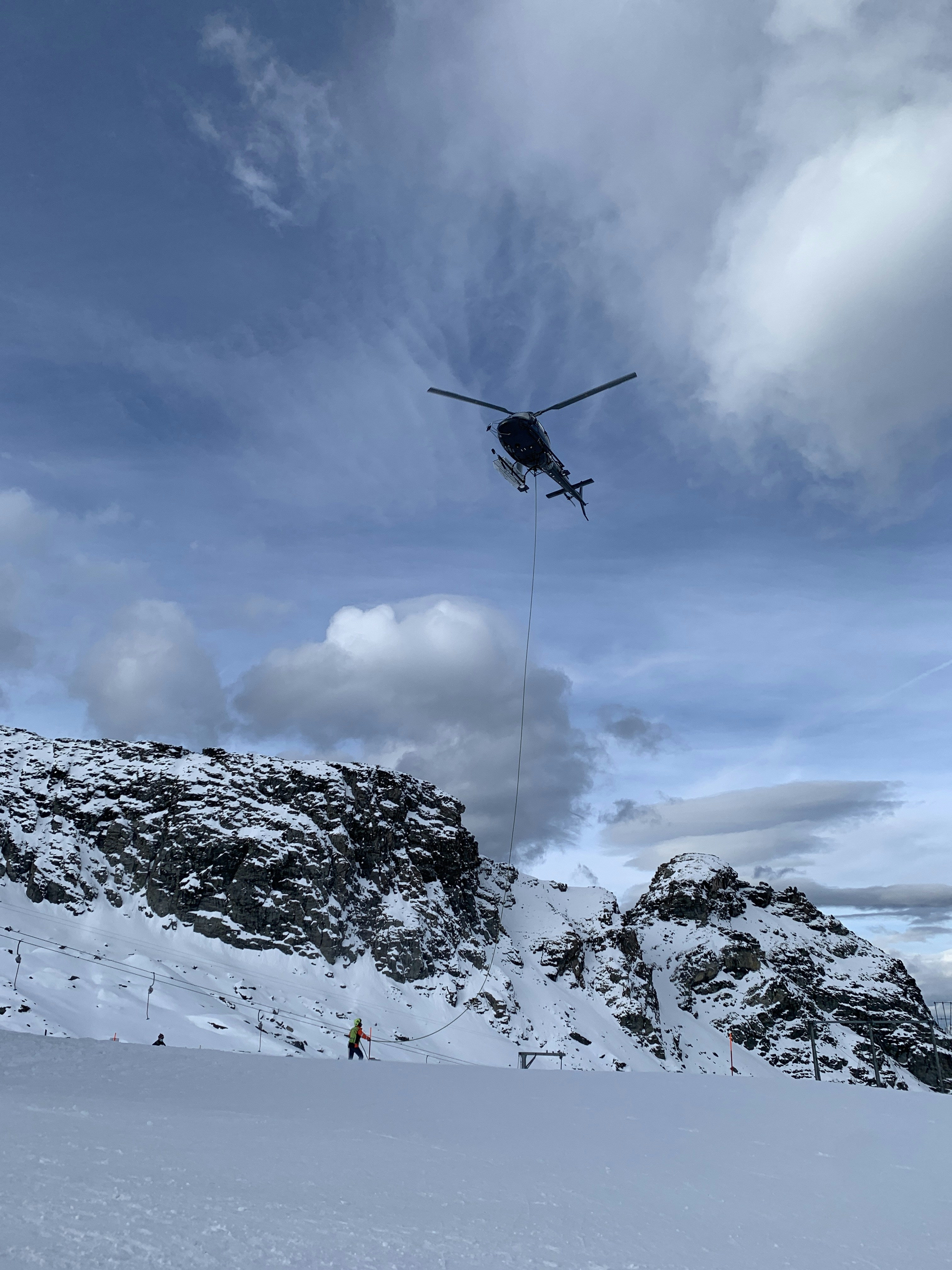 Black and white bird flying over snow covered mountain under blue and ...