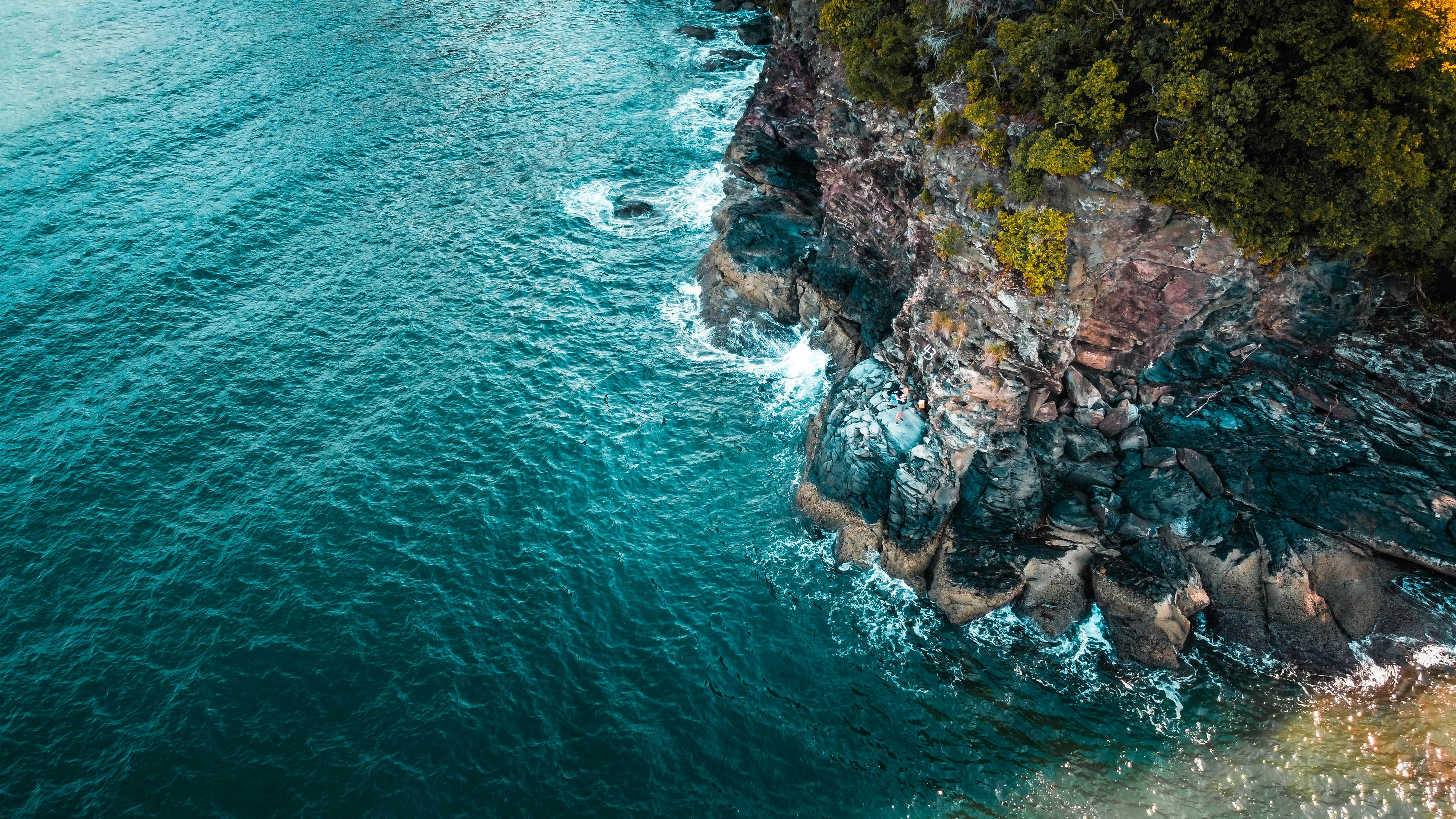 Brown rocky mountain beside body of water during daytime photo – Free ...