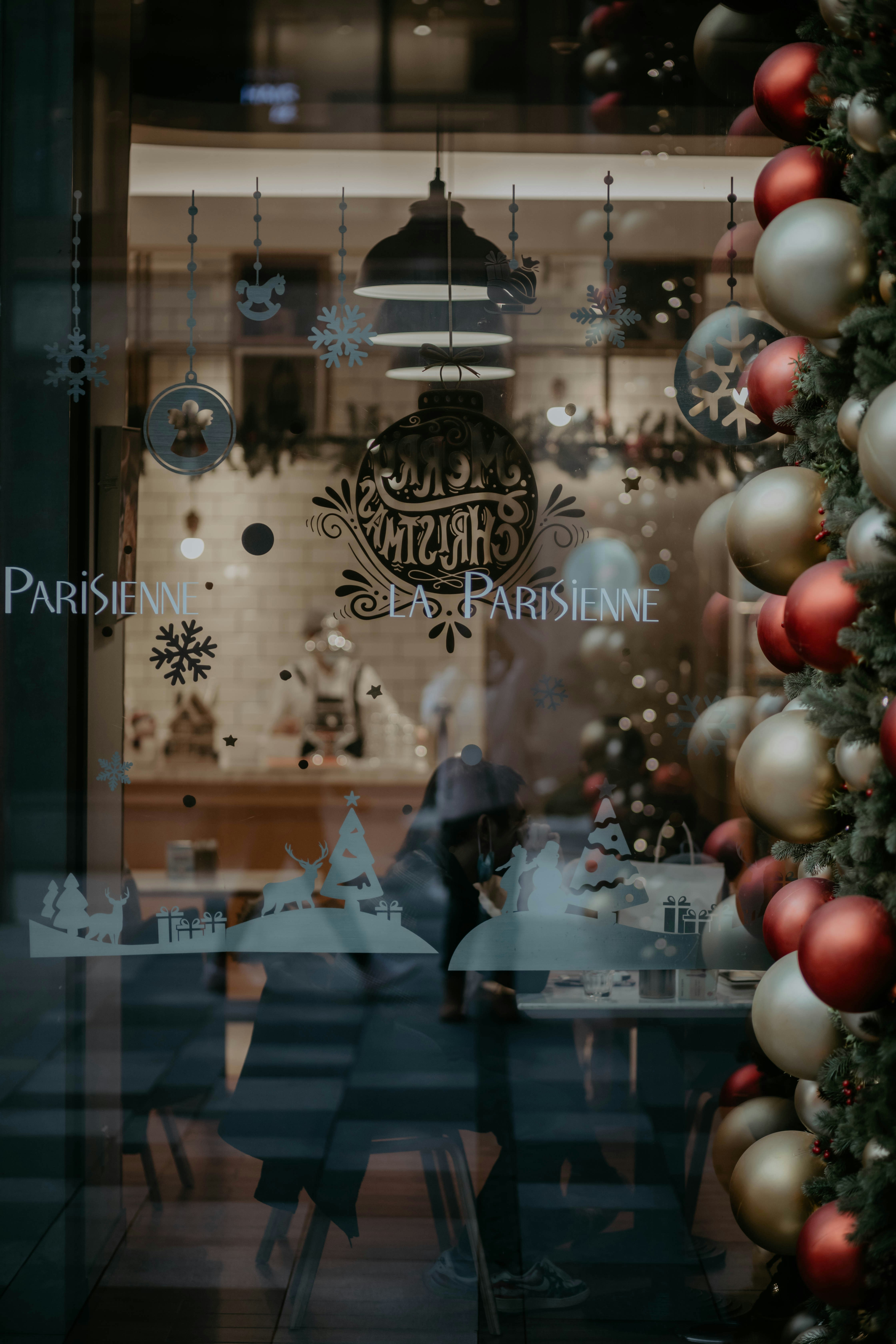 La Parisienne Window: Christmas Ornaments and Warm Reflections in Glass