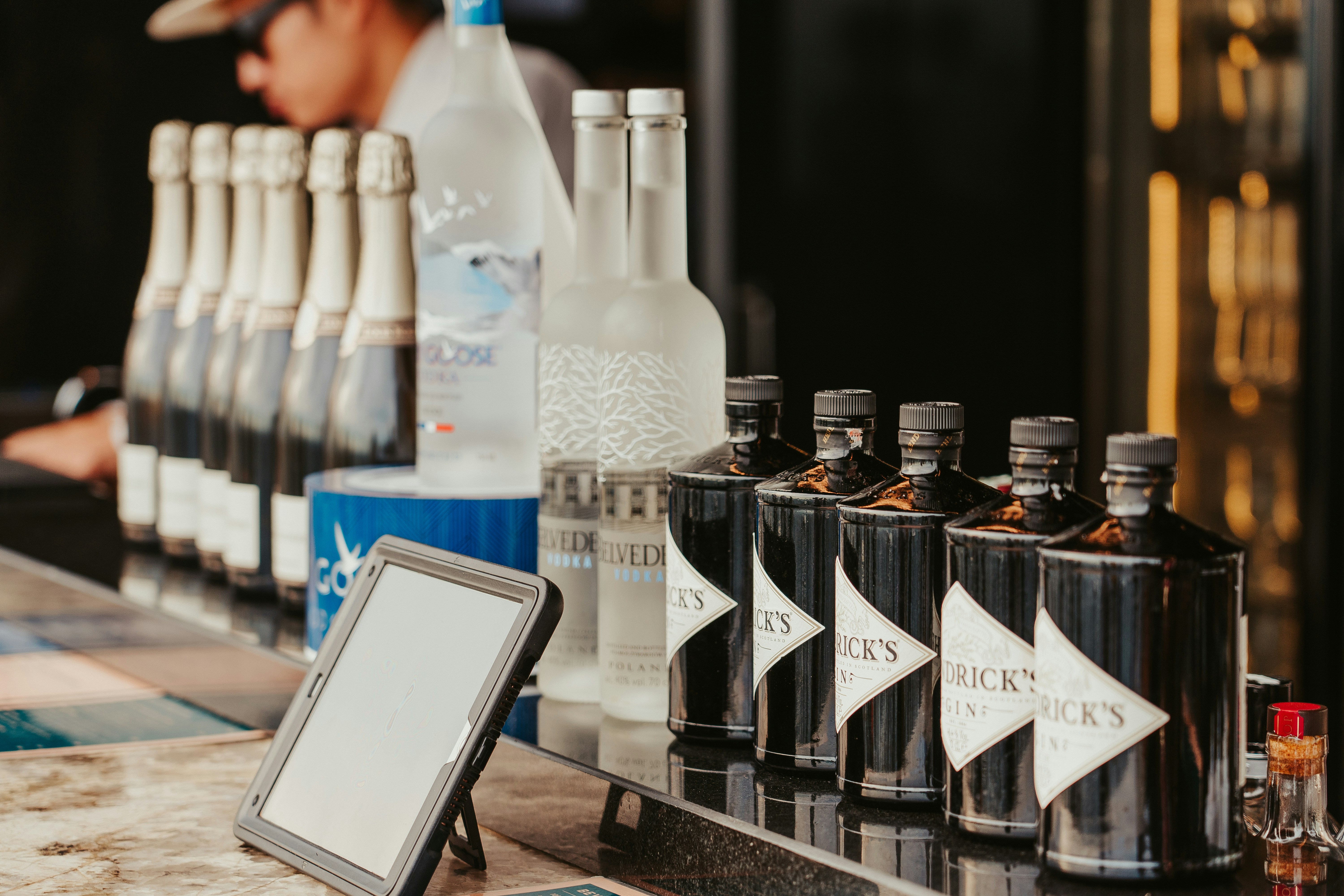 Bricks, Glass, and a Tablet: Warm Bar Lights on a Bottled Row