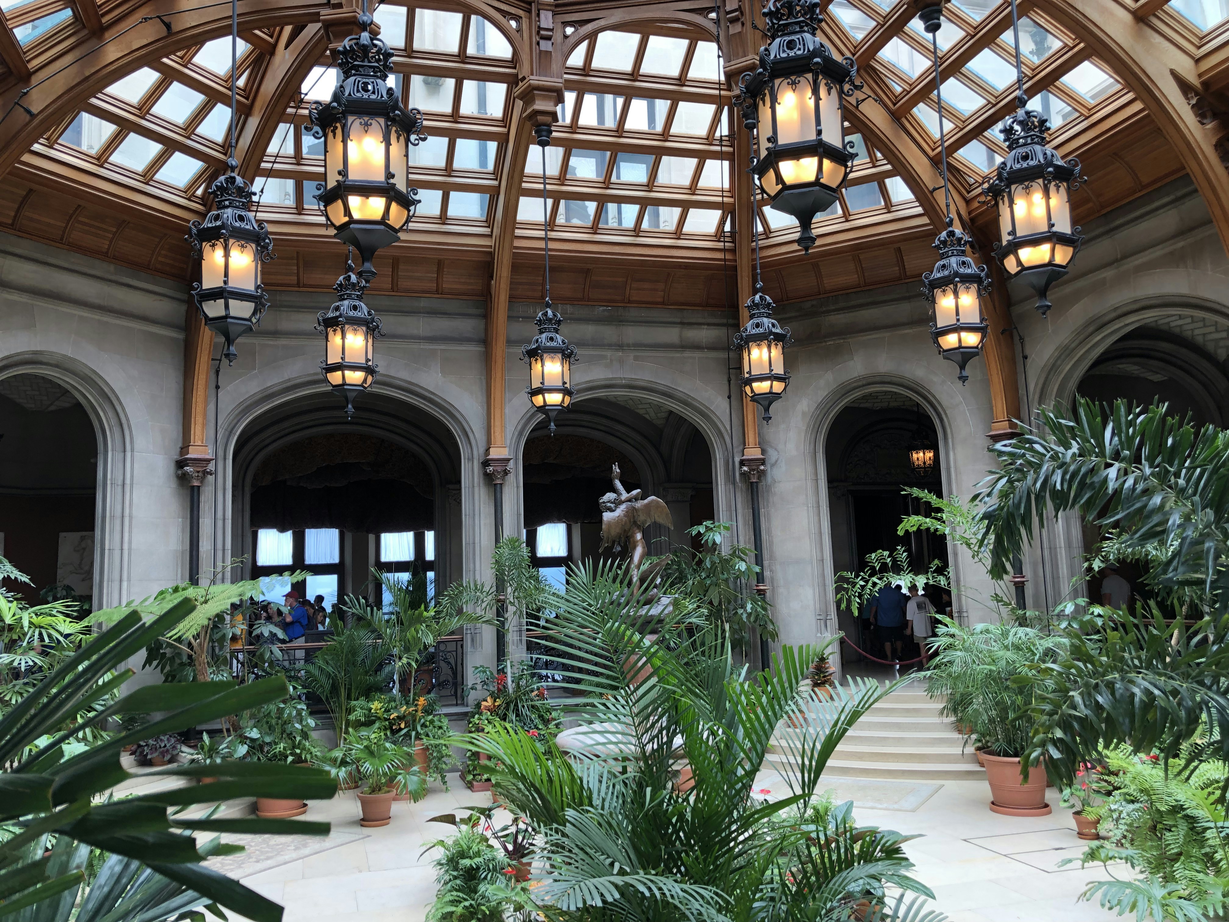 Indoor winter garden and conservatory in the main Biltmore residence, Ashville, NC | green palm plant near brown concrete building
