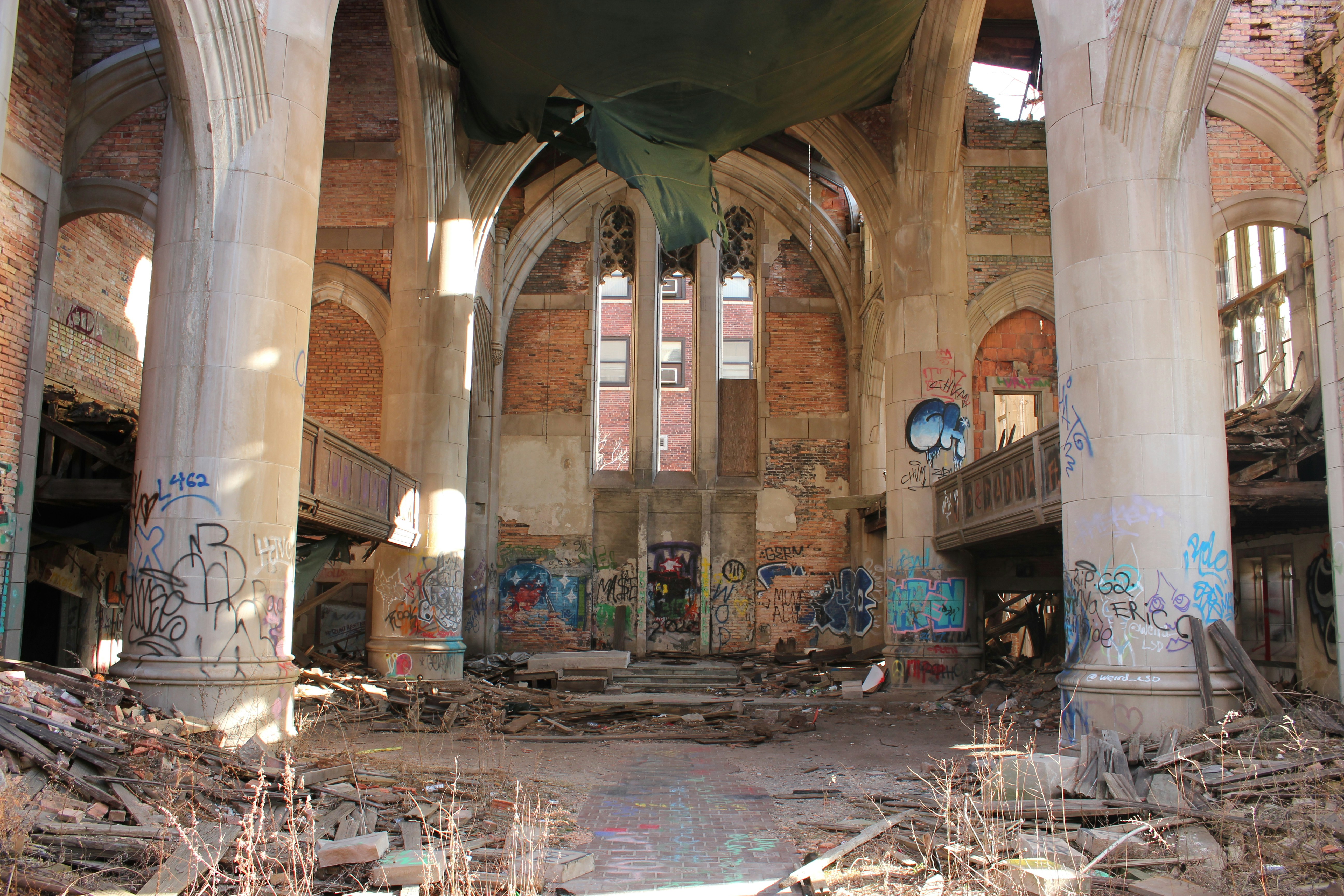 Cracked Sanctuary: Graffiti-Lined Hall Drawn Toward a Backlit Exit