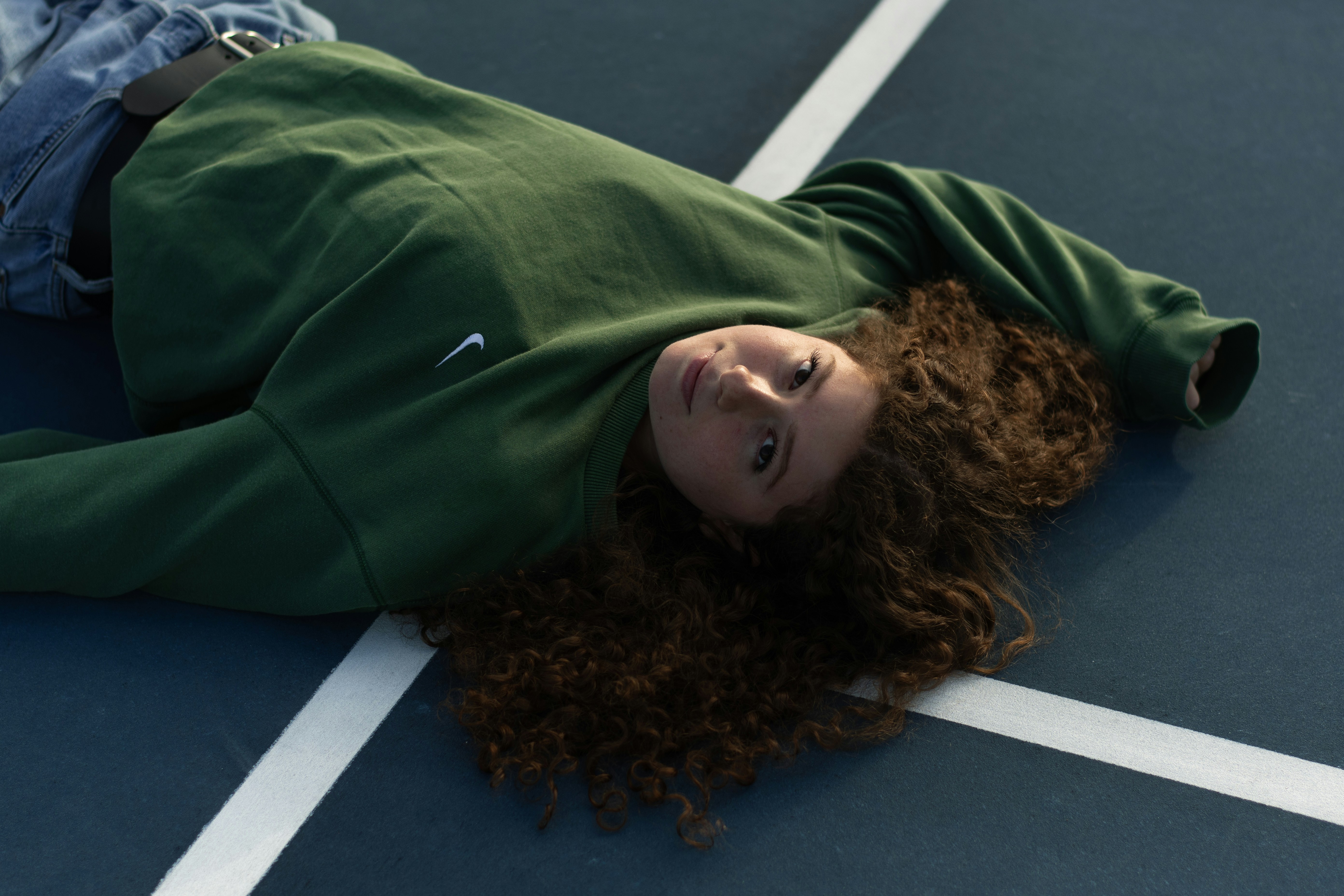 Green Hoodie Rest on a Court of White Lines