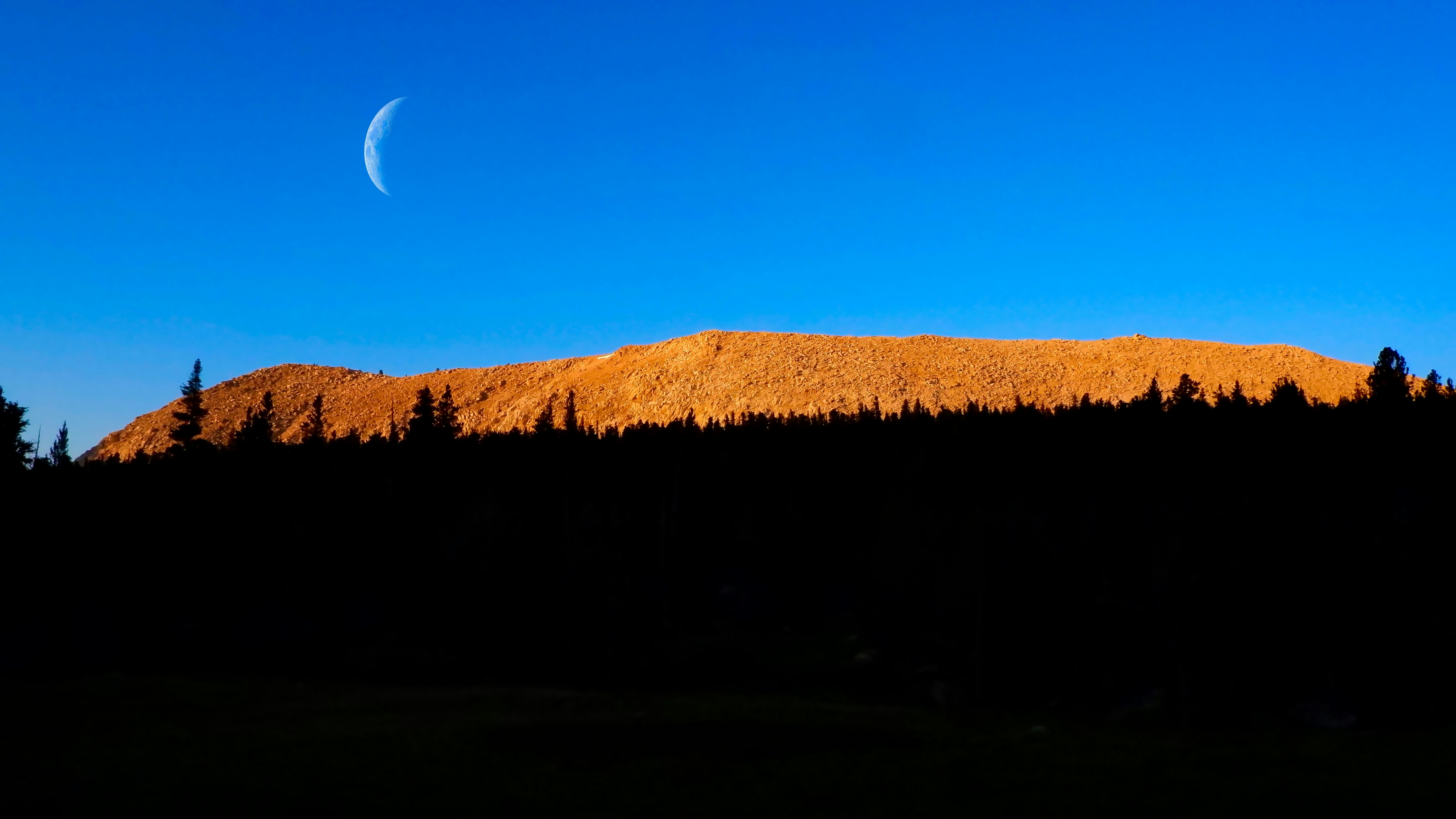 Crescent Moon Over a Blue Hour Ridge with a Golden Crest