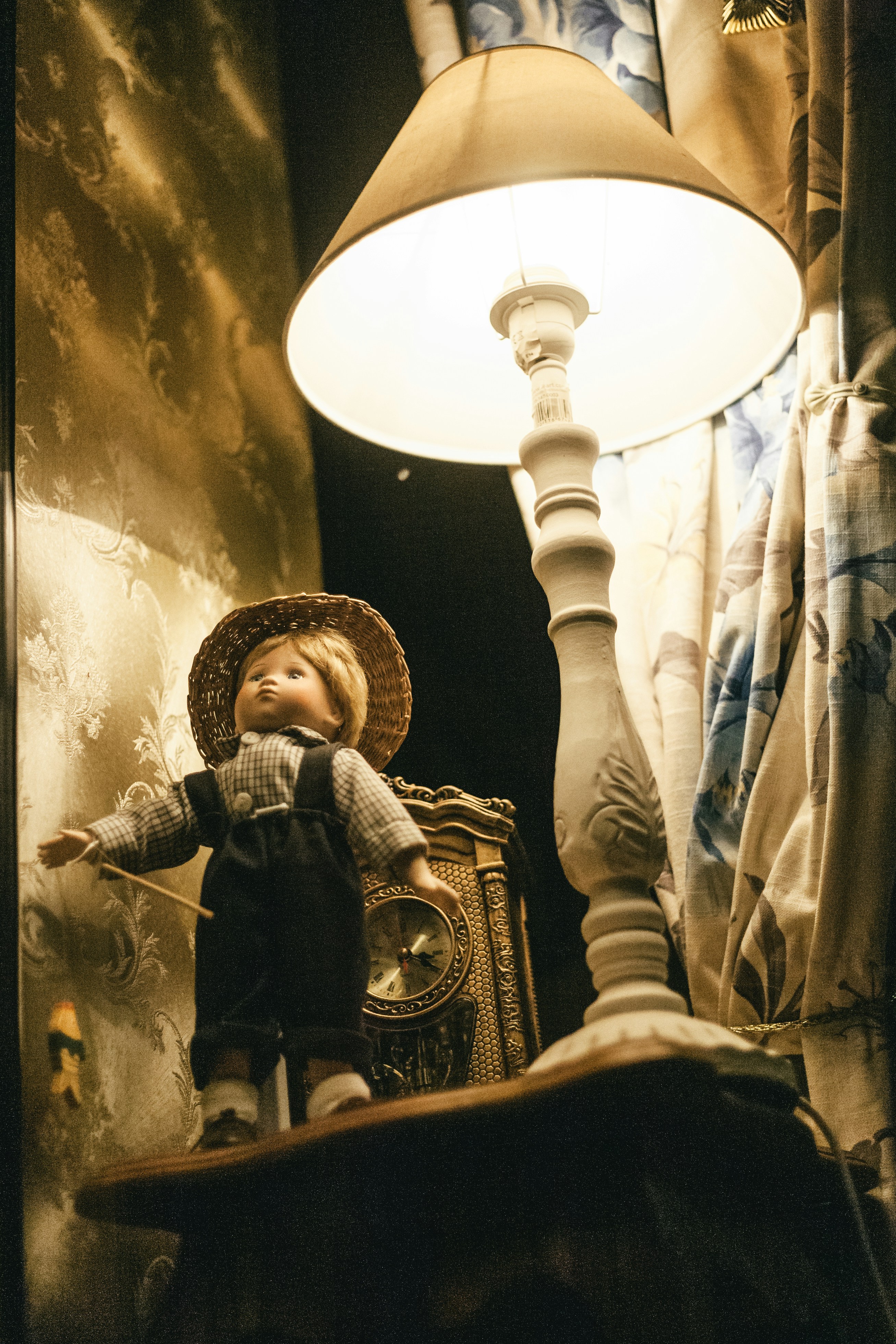 Lamplight Reverie: A Vintage Mantel Scene with Doll, Clock, and Drapes
