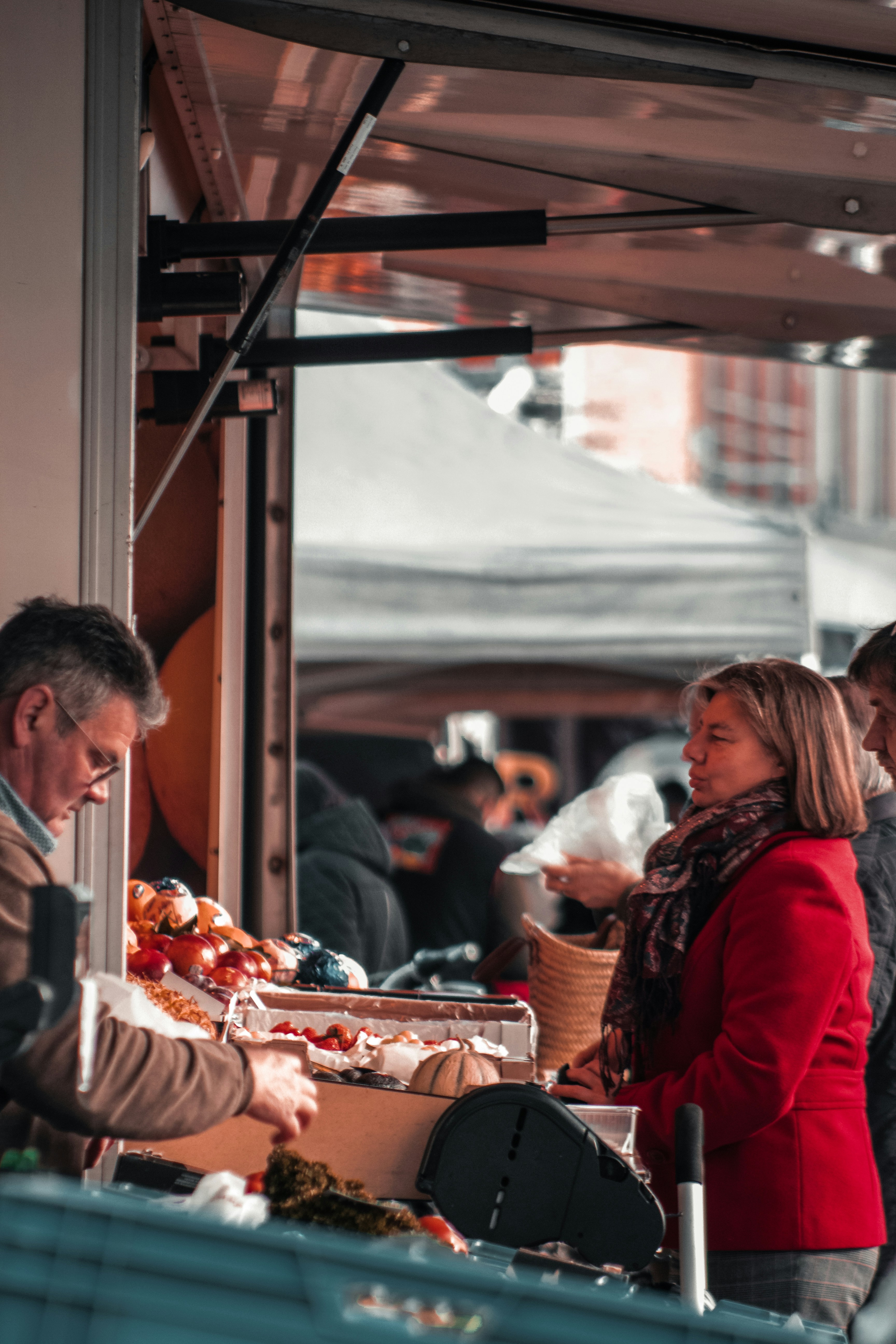 Red-coated shopper at a bustling market stall