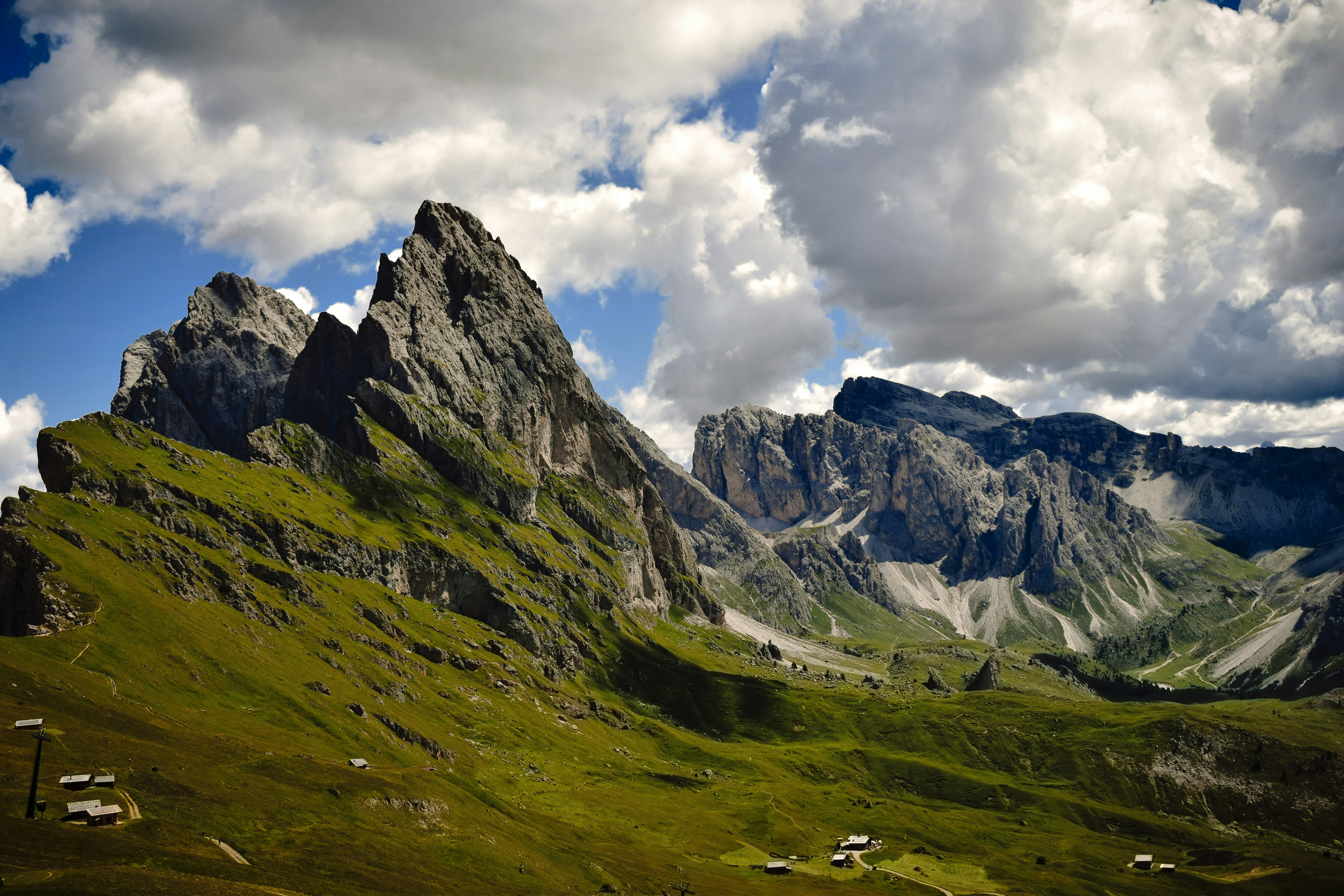 Val gardena in the summer | green and gray mountains under white clouds and blue sky during daytime