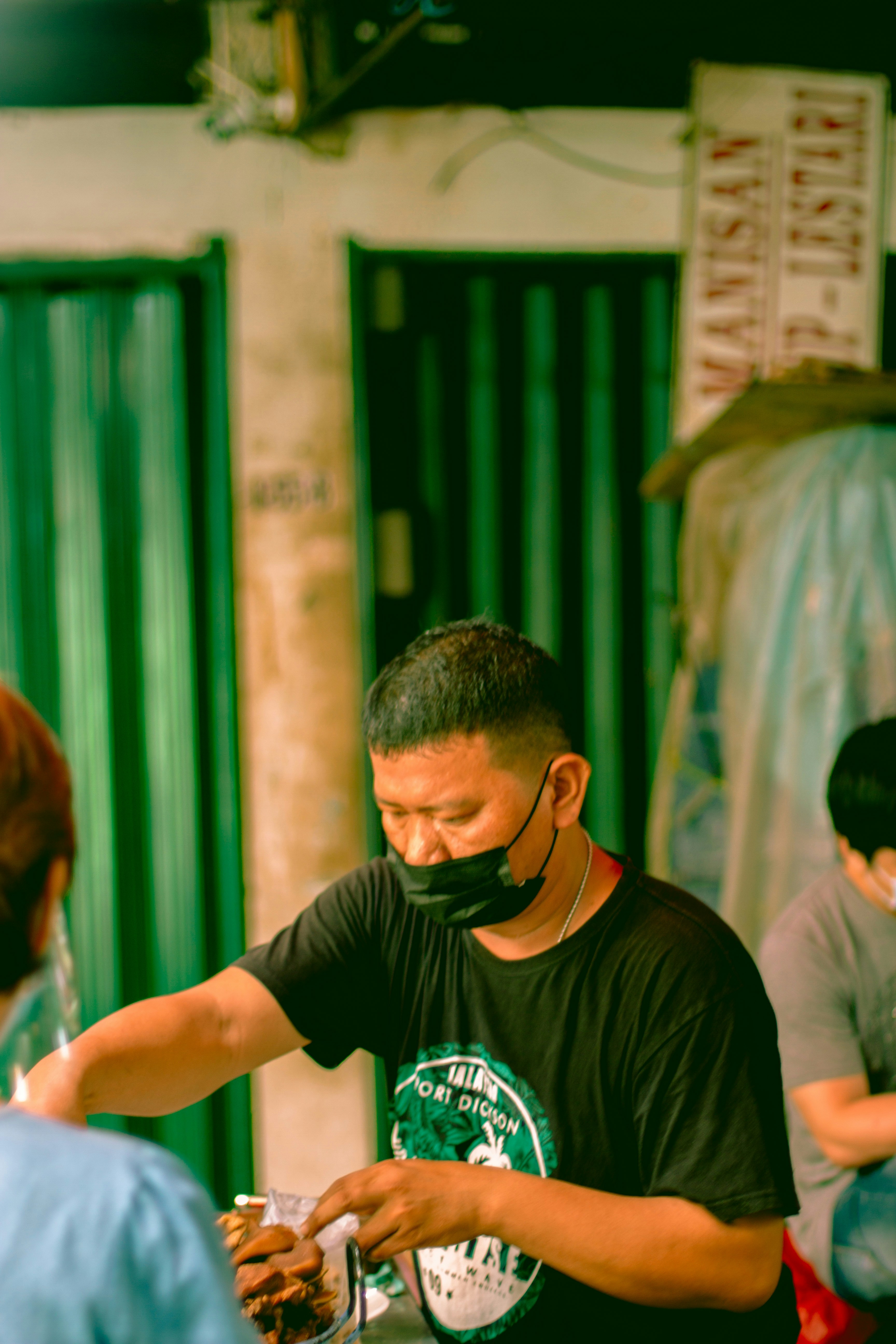 A vendor skillfully prepares food in a bustling market, surrounded by vibrant colors and textures that evoke a lively atmosphere.