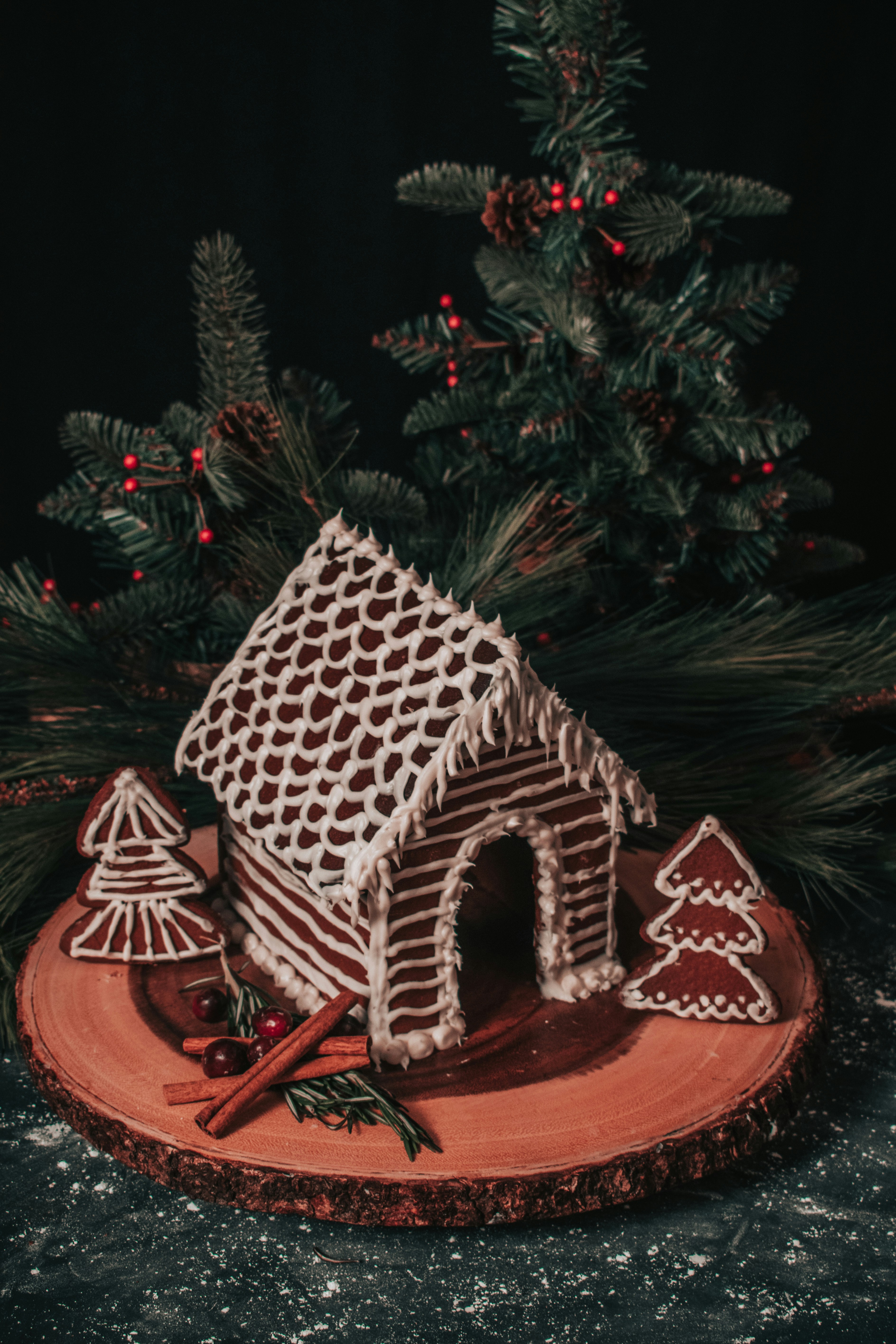 Gingerbread House on a Wooden Ring Stage, Framed by Festive Evergreens