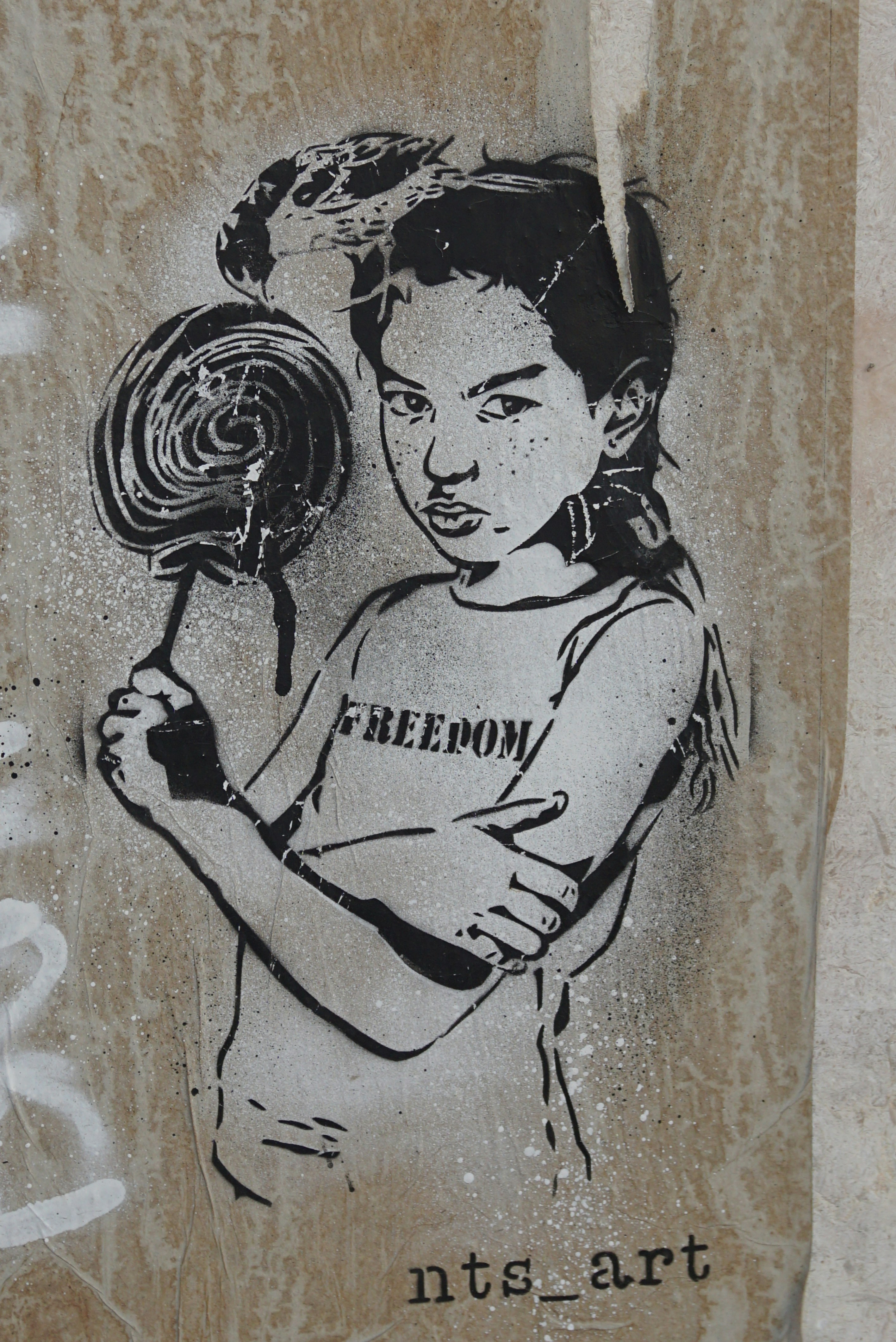 Freedom in Spray: A Girl with a Lollipop Stencil on Concrete