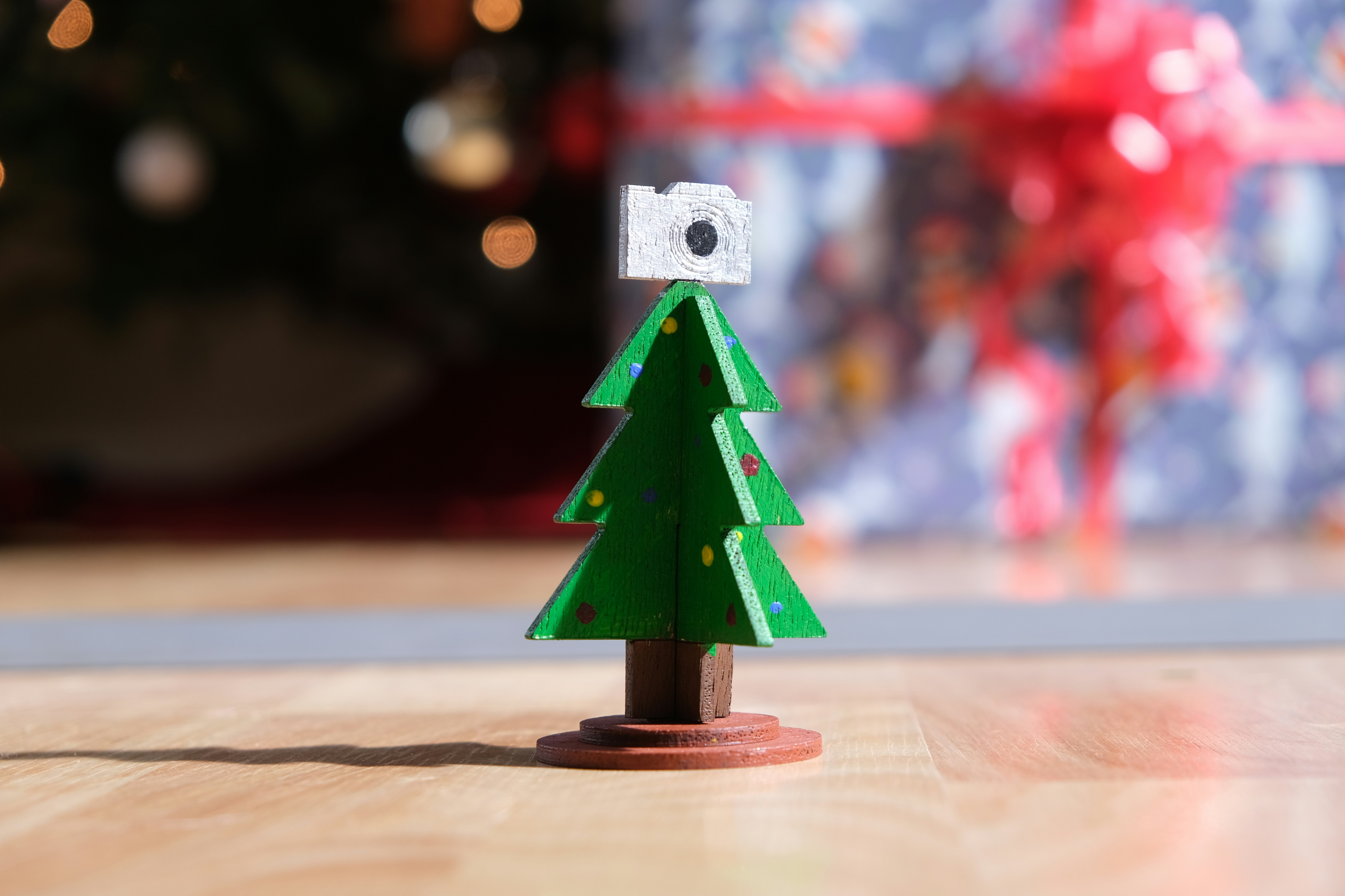 Tiny Wooden Christmas Tree on a Table Adorned by Holiday Bokeh