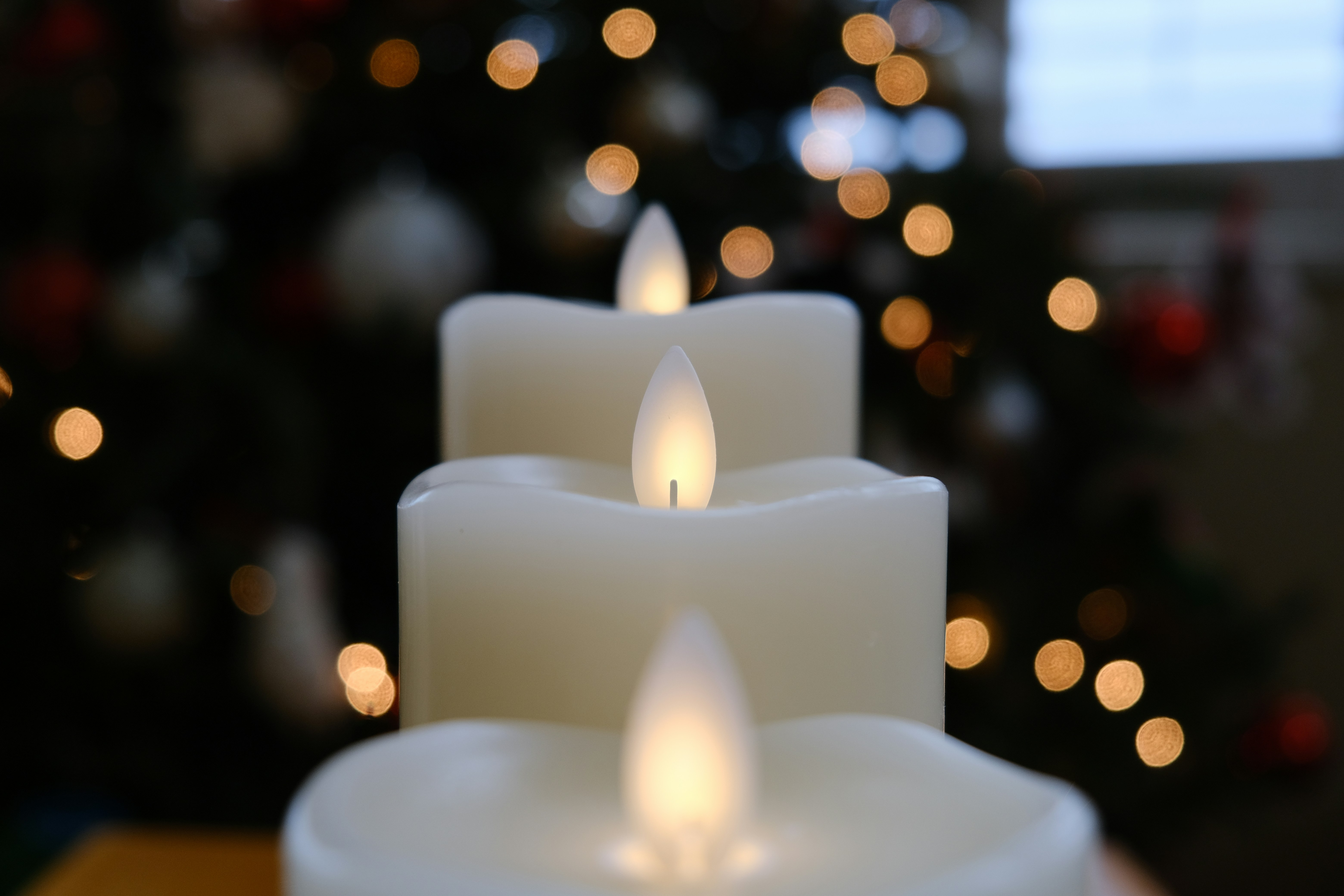Three Candles in Gentle Focus Against a Warm Holiday Glow