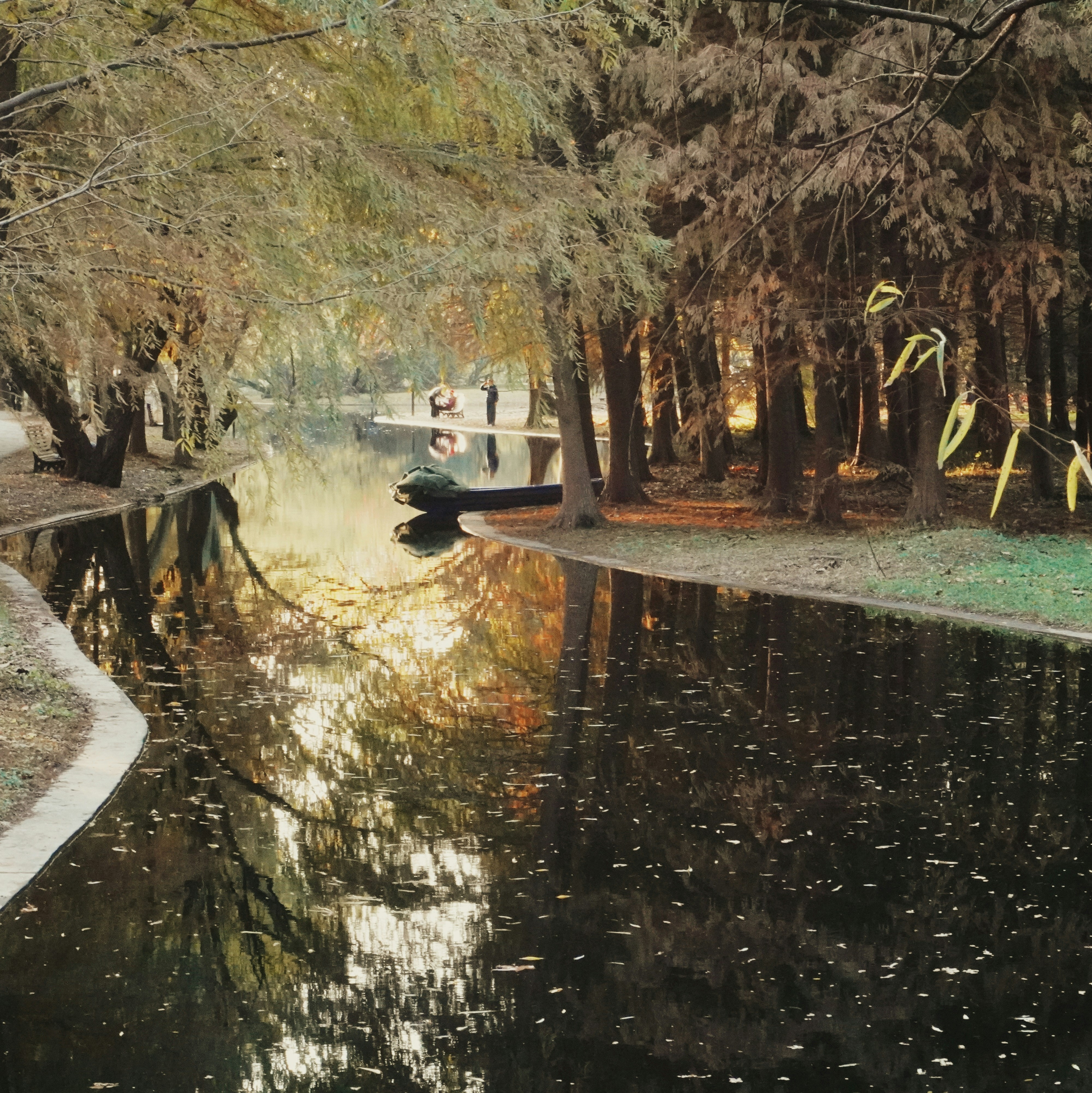 Autumn Canal: A Small Boat Resting Amid Reflected Light