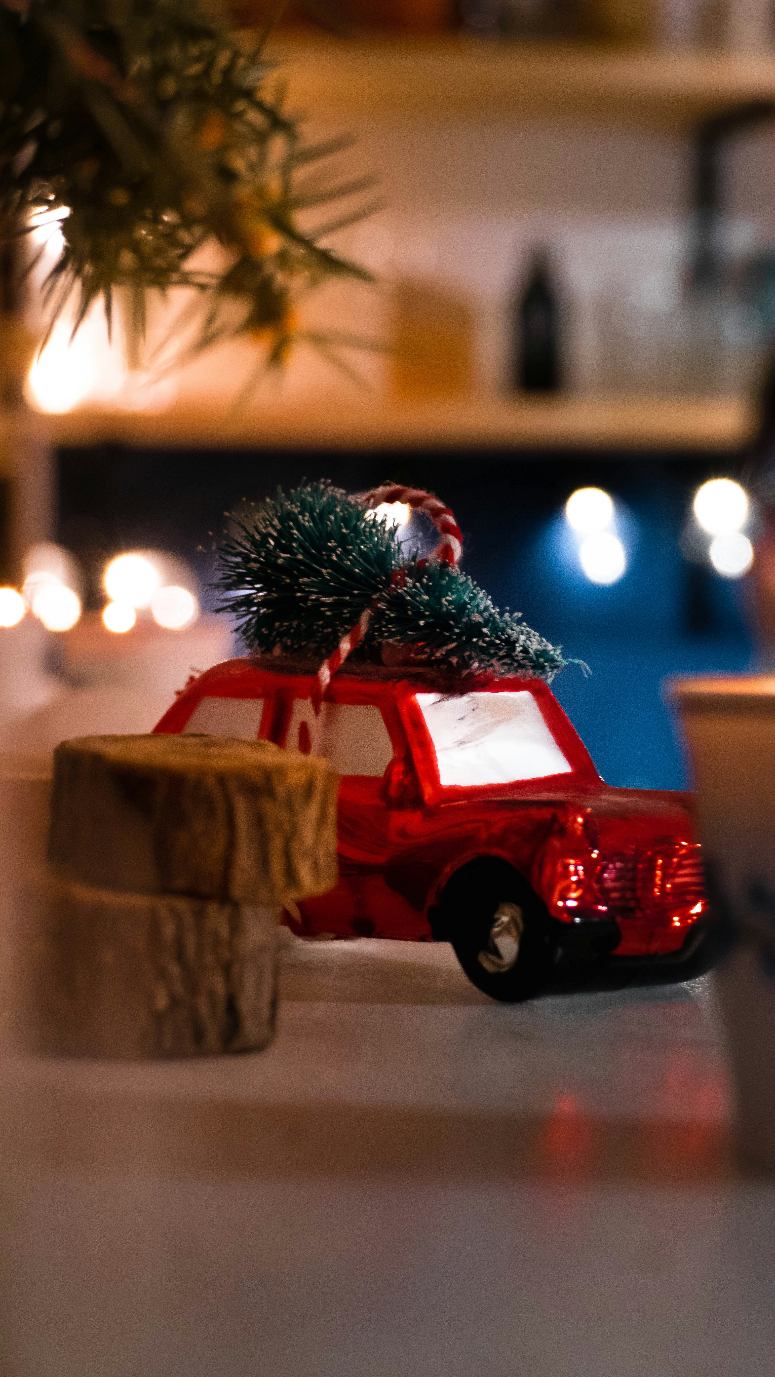 Red Toy Truck Carrying a Christmas Tree Beneath Warm Kitchen Lights